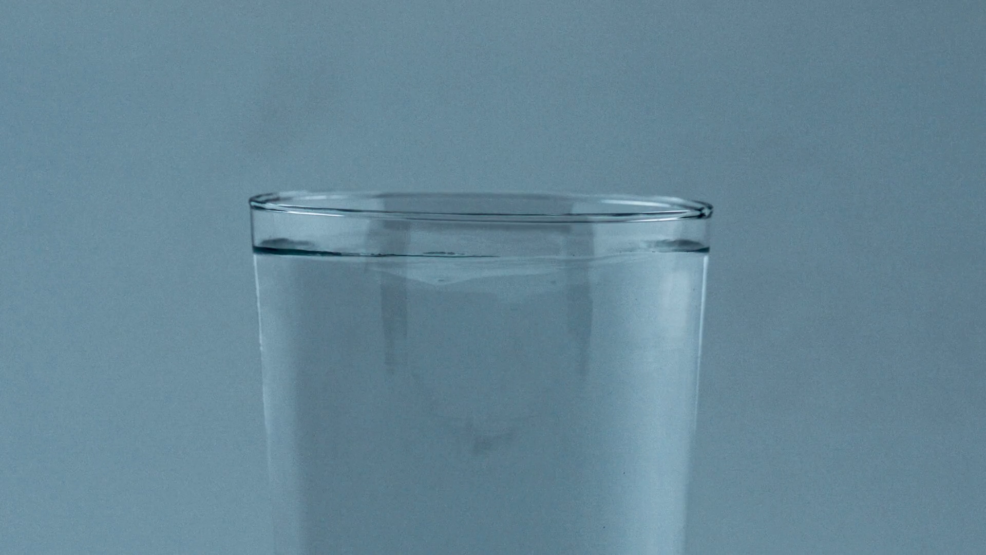 Pure beverage spinning transparent cylinder closeup. Mineral water ...