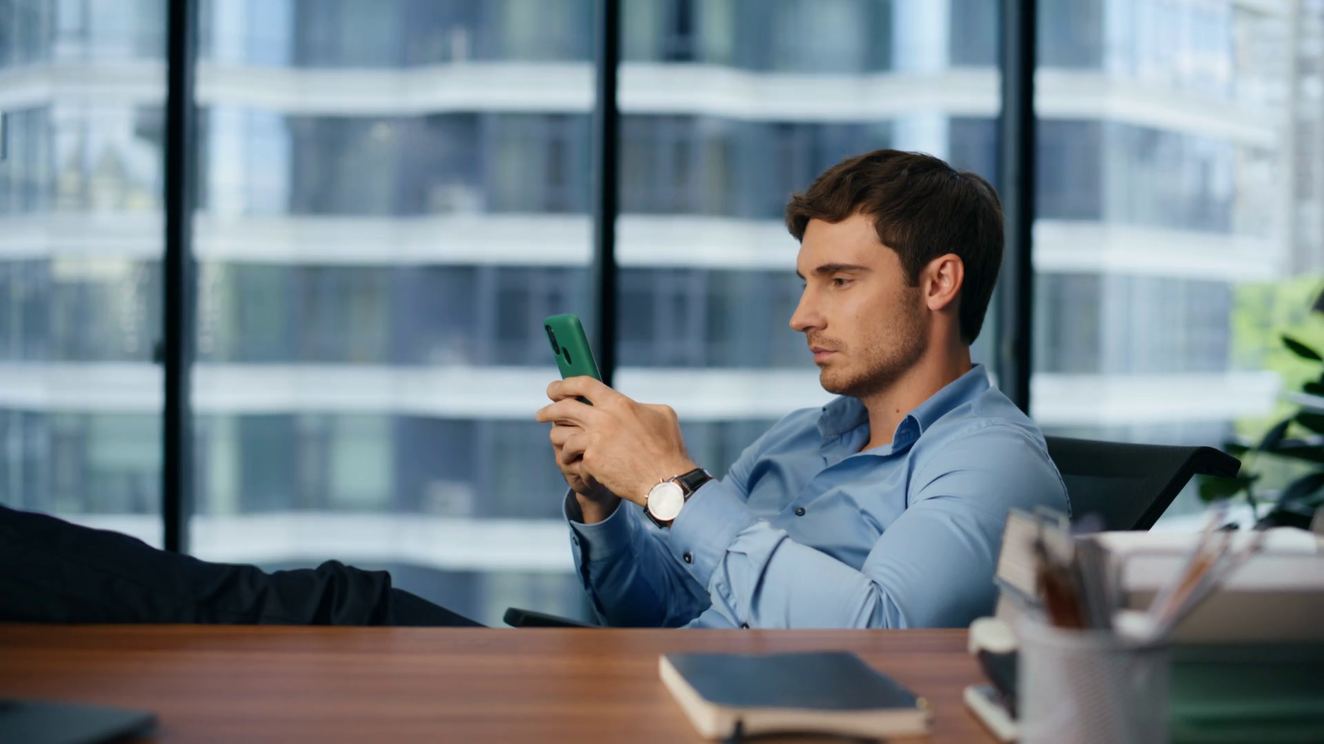 Serious boss working smartphone in panoramic place. Focused businessman ...