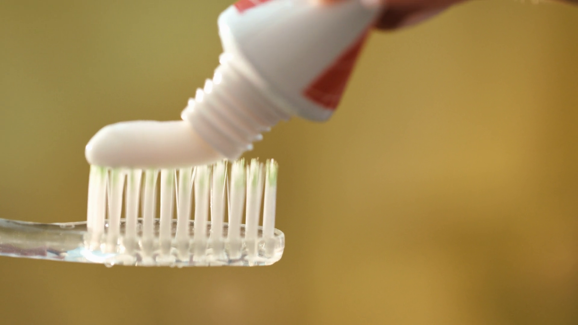 Close up squeezing white toothpaste on toothbrush. Macro shot of ...