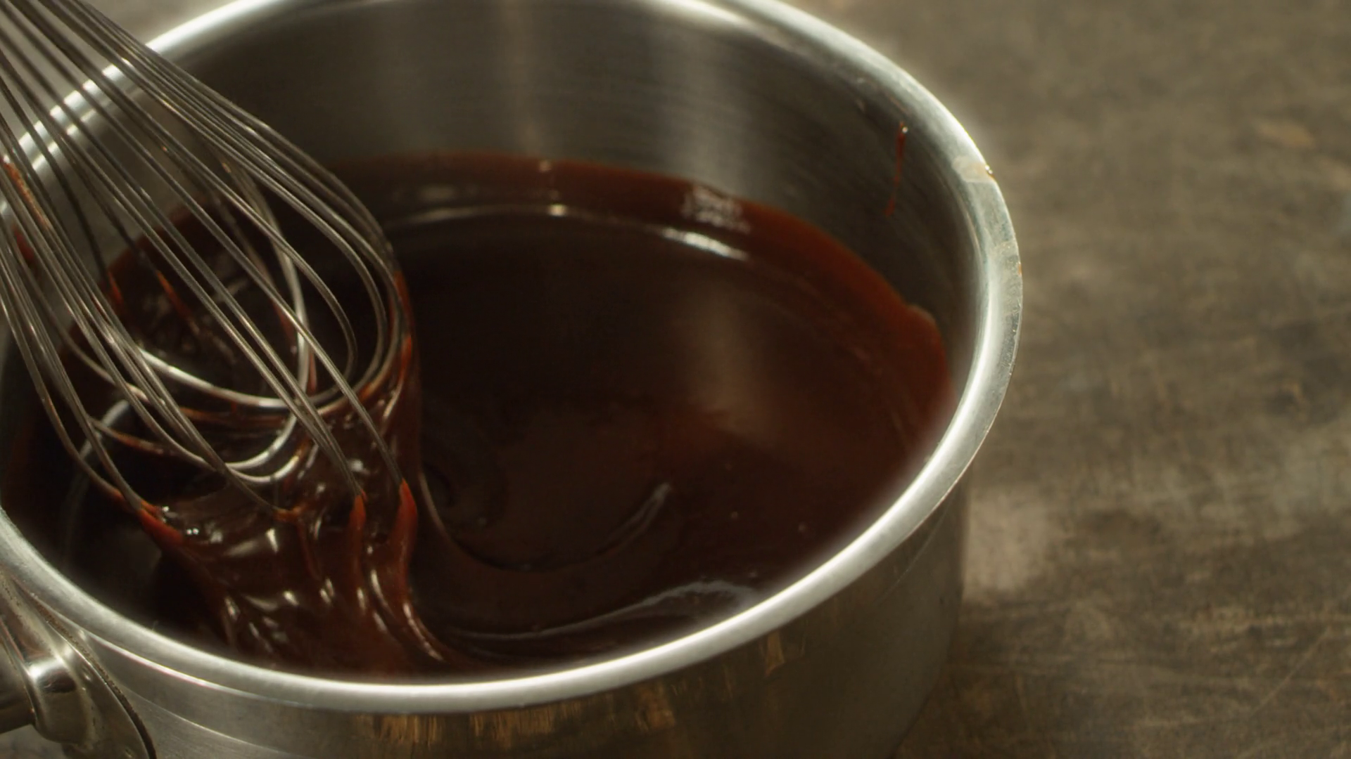 Closeup of liquid chocolate mixing with whisk in slow motion. Process ...