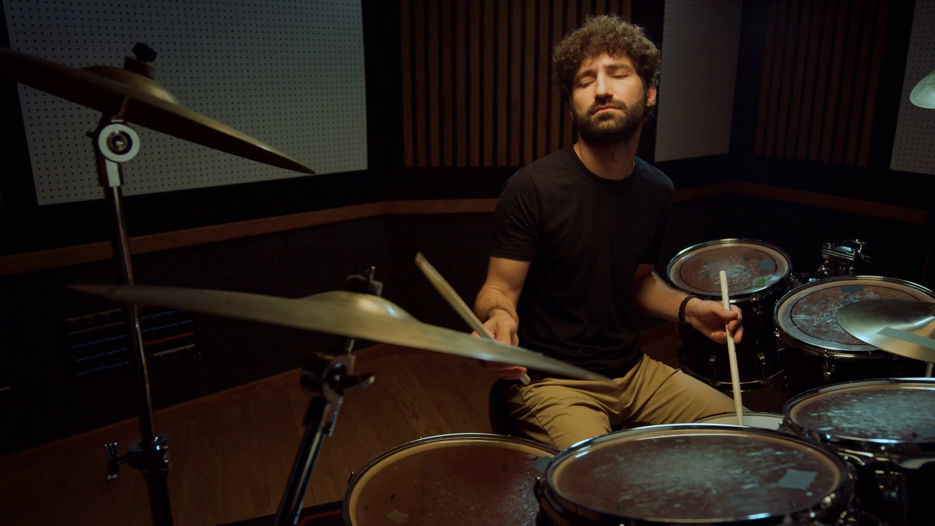 Emotional drummer playing on drum kit indoor. Expressive artist closing ...
