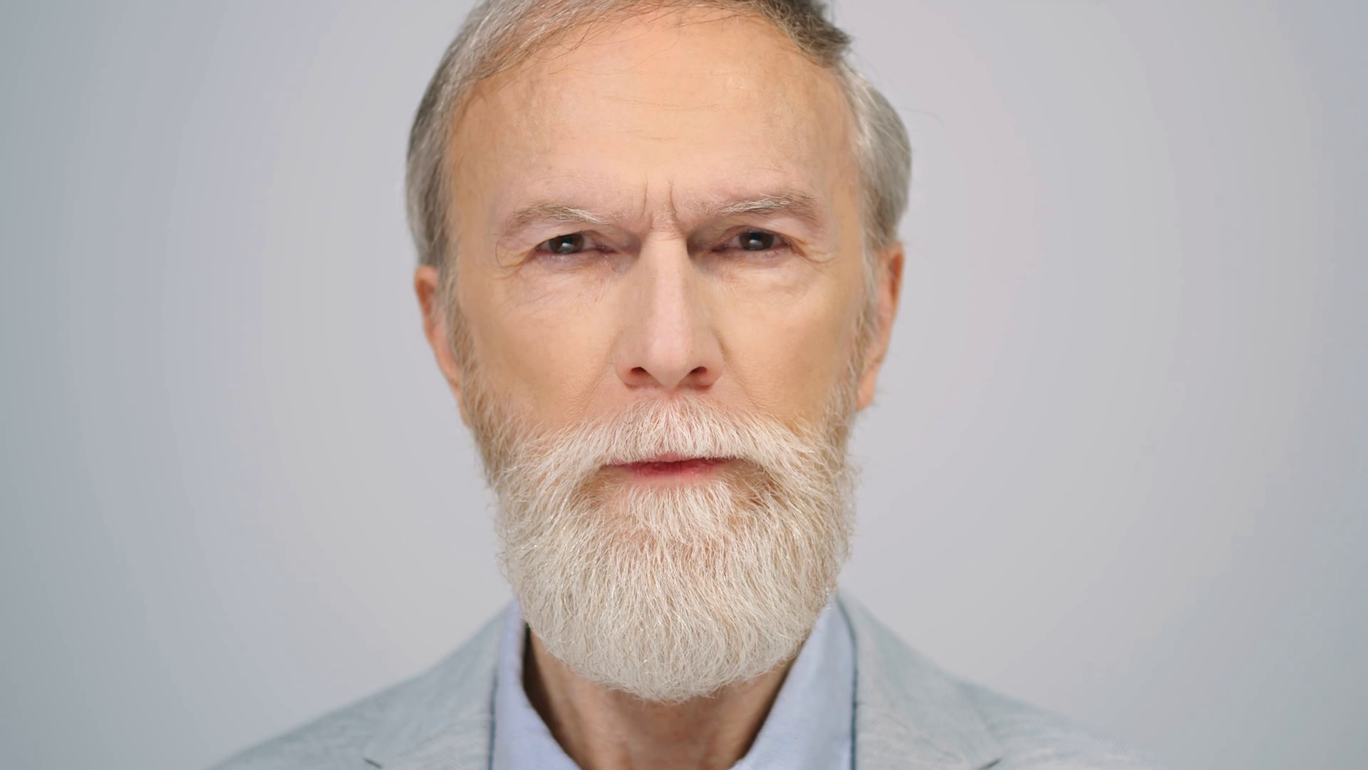 Old man portrait with shocked face expression at grey background. Surprised senior male person ...