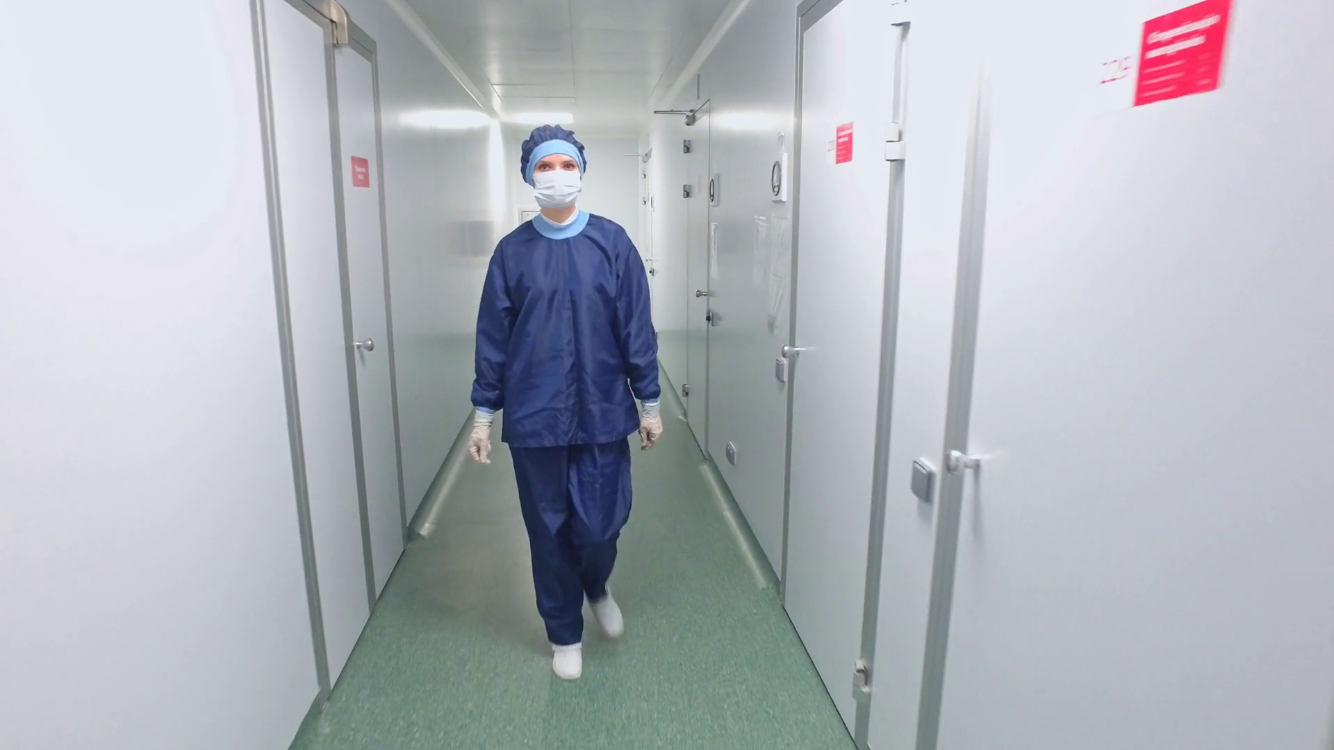 Pharmaceutical factory worker go in sterile corridor. Steadycam shot of ...