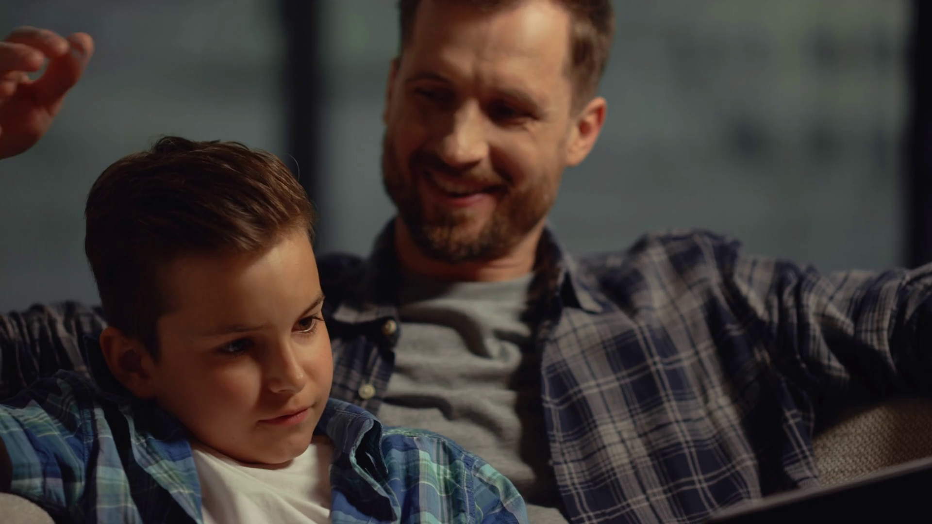 Portrait Of Cheerful Father And Son Looking Computer Screen Indoors