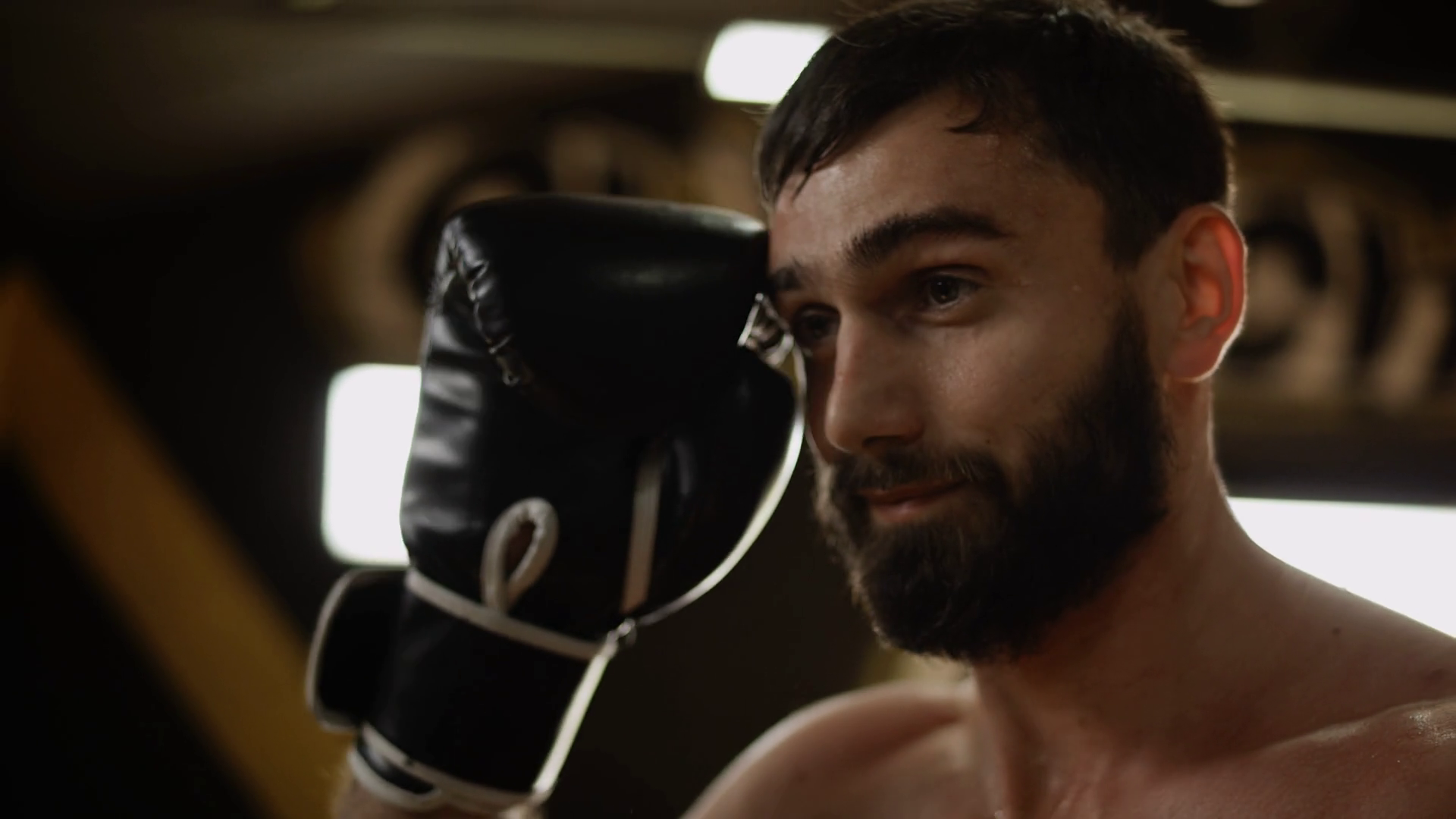 Tired boxer wiping sweat from face at hard training. Tired man wiping ...