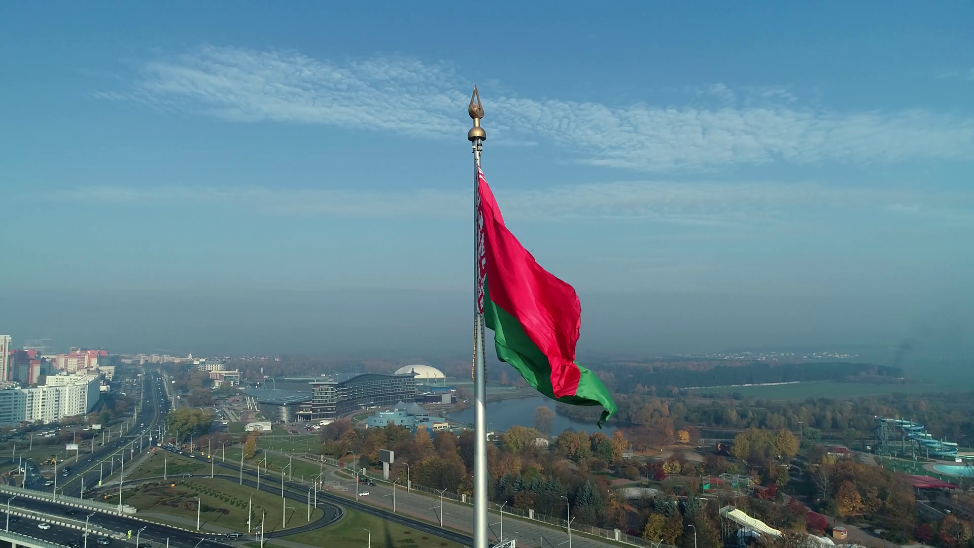 Belarusian flag waving over blue sky and Minsk cityscape on a sunny ...