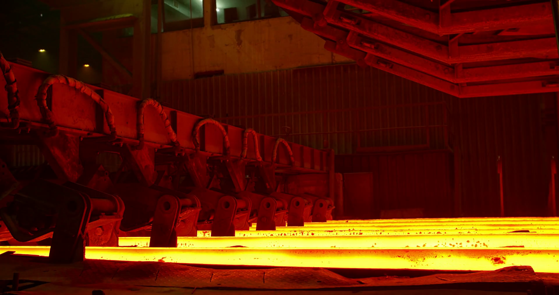 Metallurgical plant, red-hot metal bar on the conveyor. Hot iron in the ...