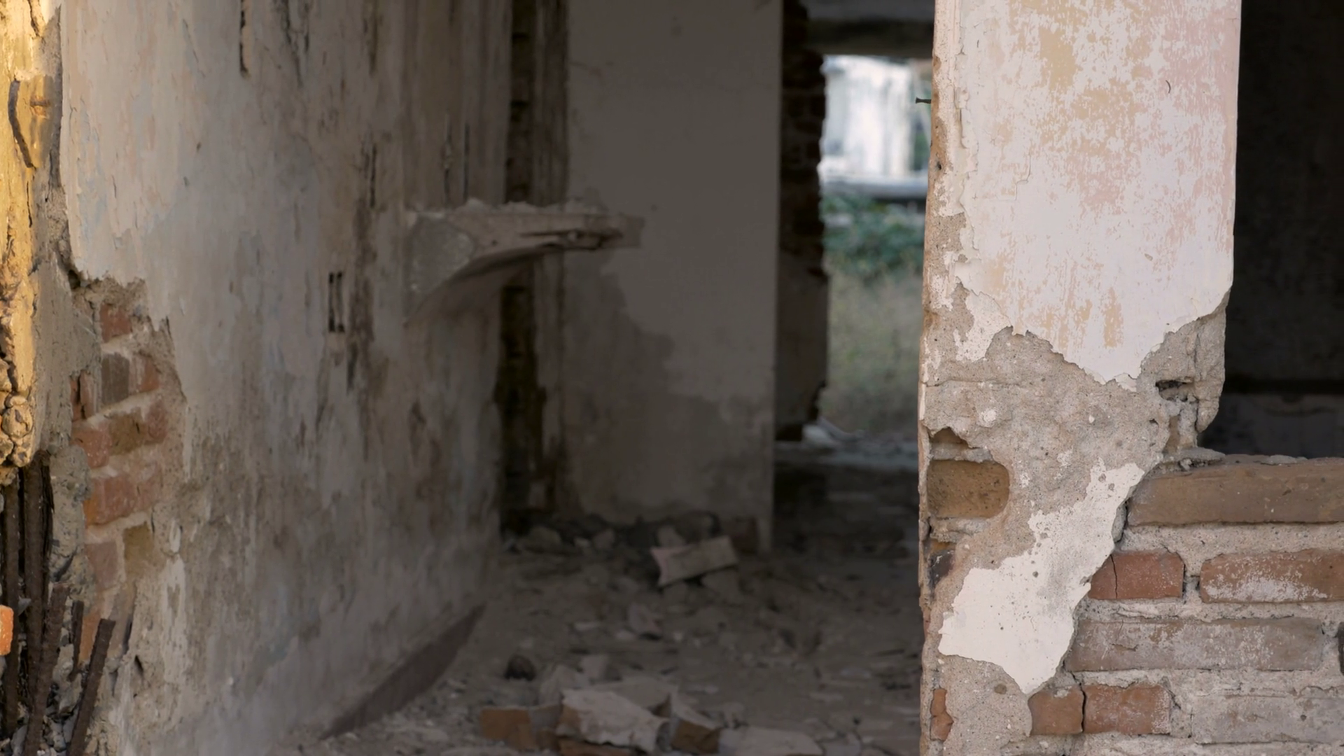 A destroyed hotel room with crumbling walls, brick, and floors from a ...