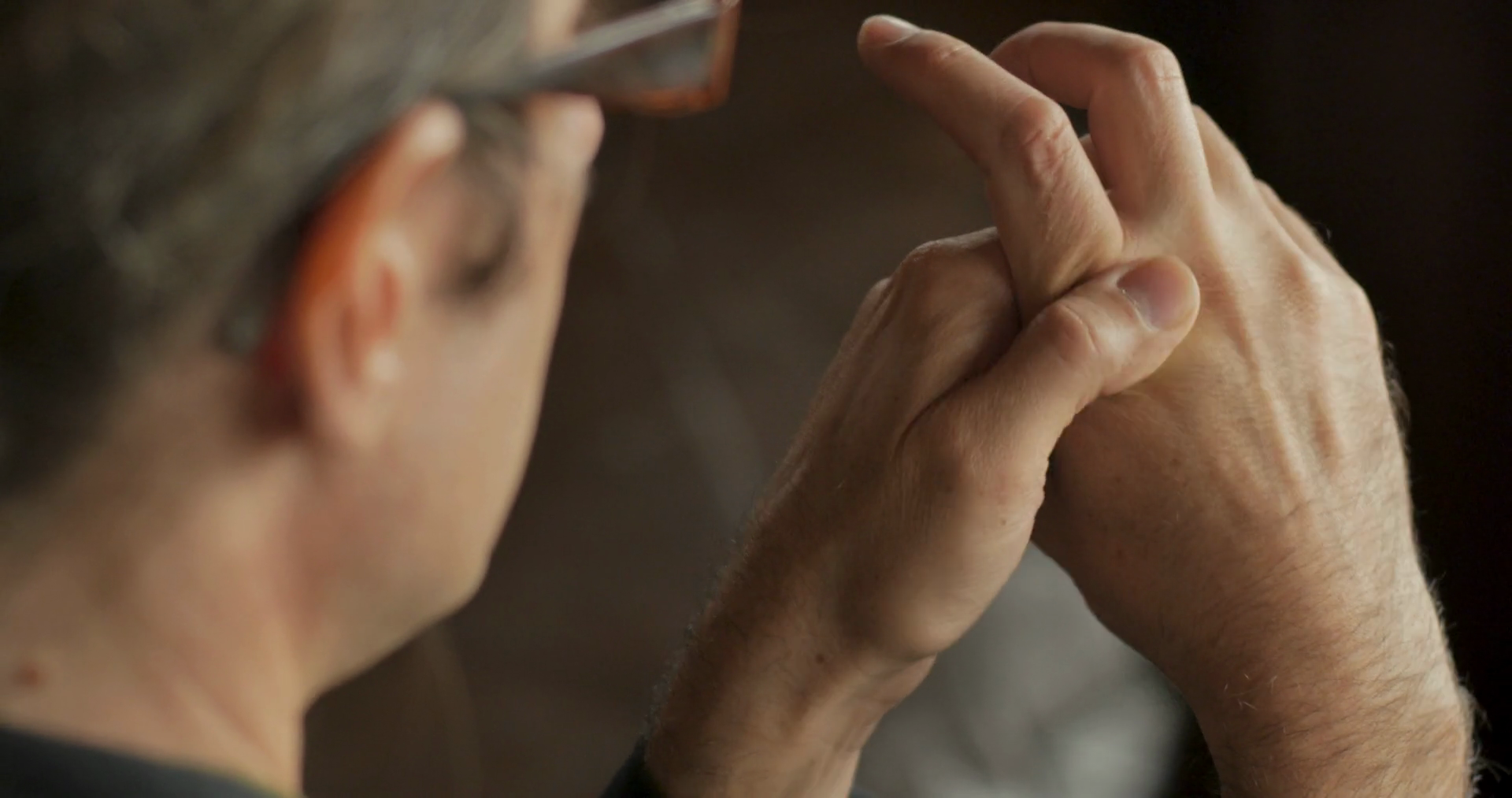 Man rubbing the joints of his fingers and hand like he is in pain from ...