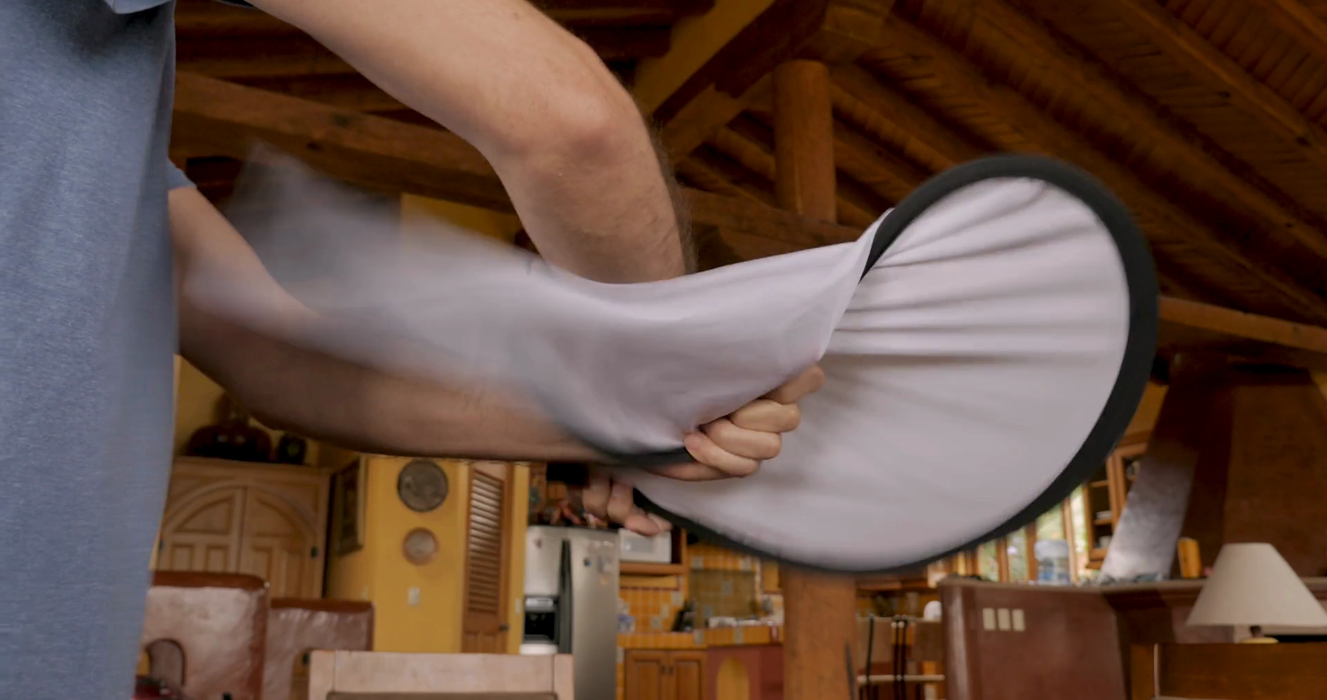 Man tries unsuccessfully to fold up a collapsible photography light ...