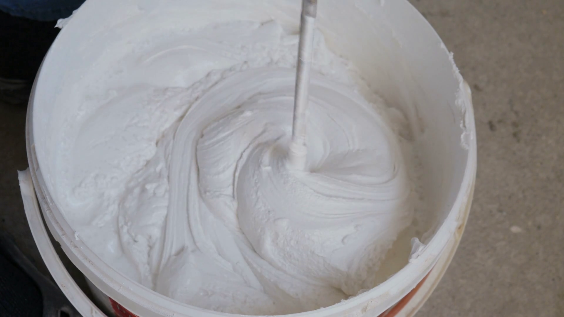 Builder mixing plaster in a bucket using an electric mixer Stock Video ...