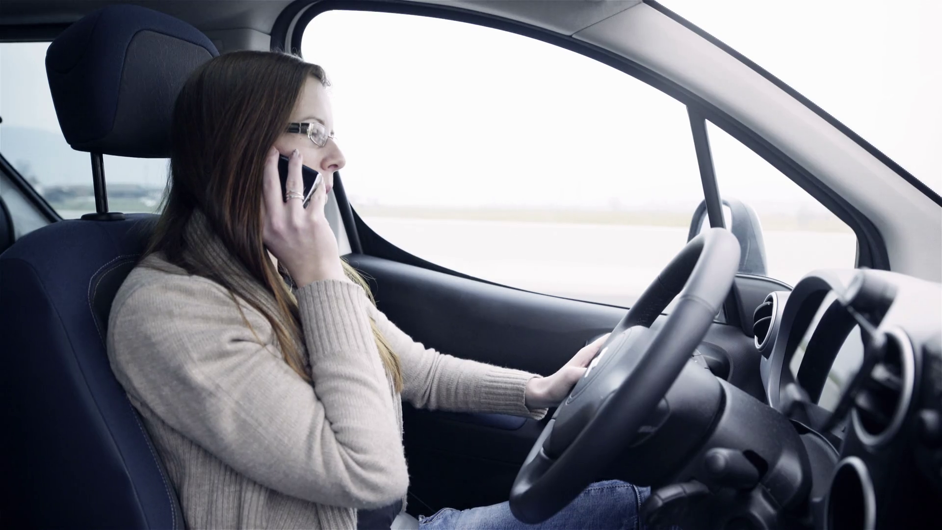 Driving and talking on mobile phone 4K. Female person in beige sweater ...