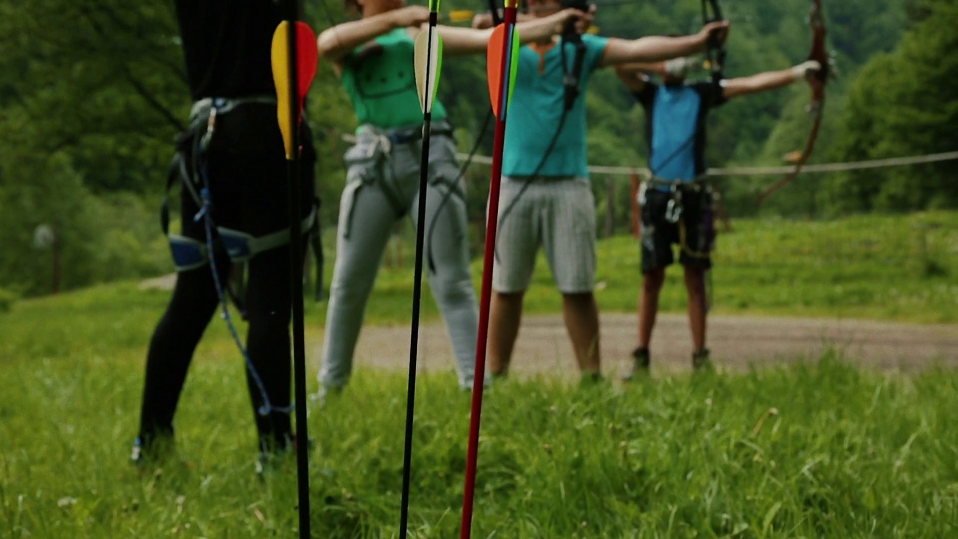 Profile of four archers in a row aiming their bows in an archery ...