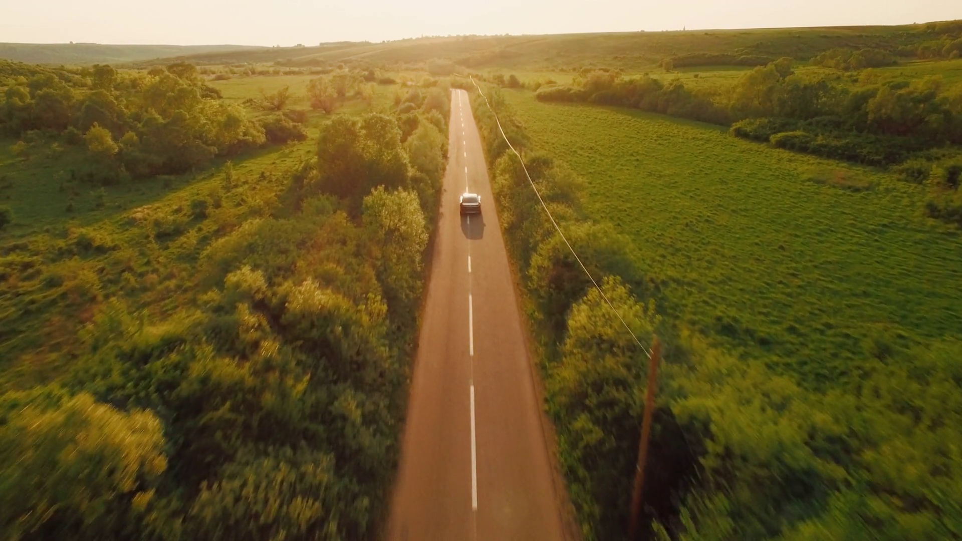 Car passing through green fields at sunset Stock Video Footage ...