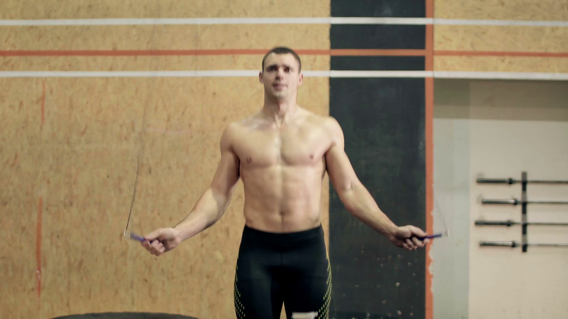 Single fit young man performing jump rope exercises at indoor gym with ...