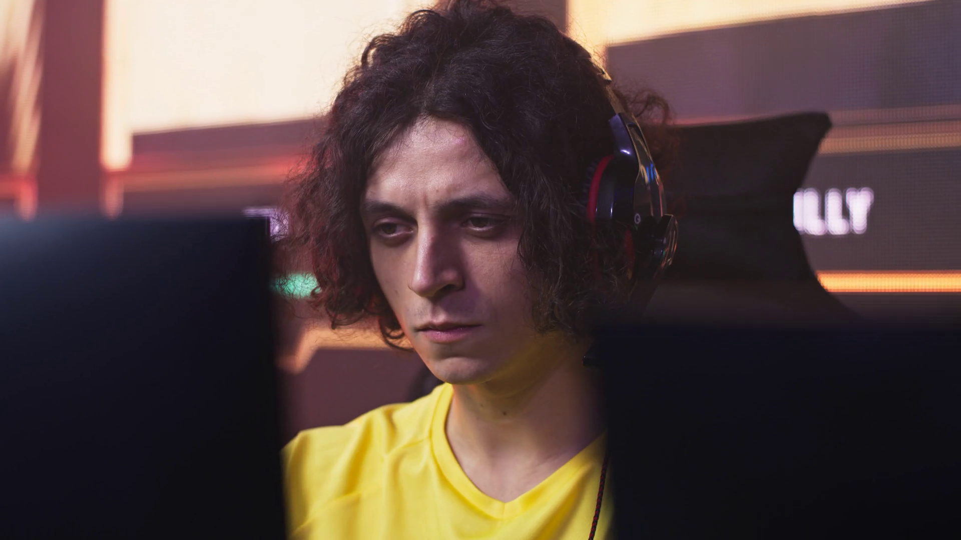 Esportsman gamer player with headset and curly hair rubbing face and ...