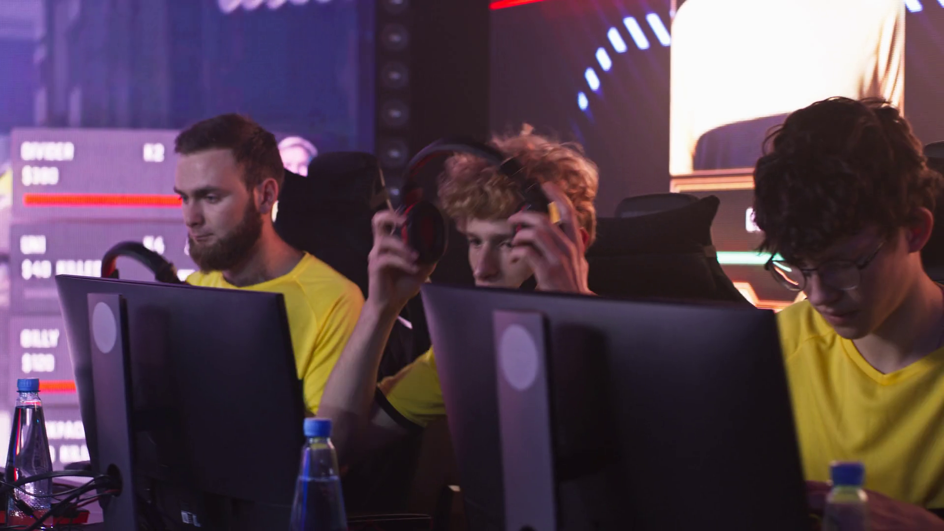 Team of diverse male gamers esportsman putting on headphones and ...