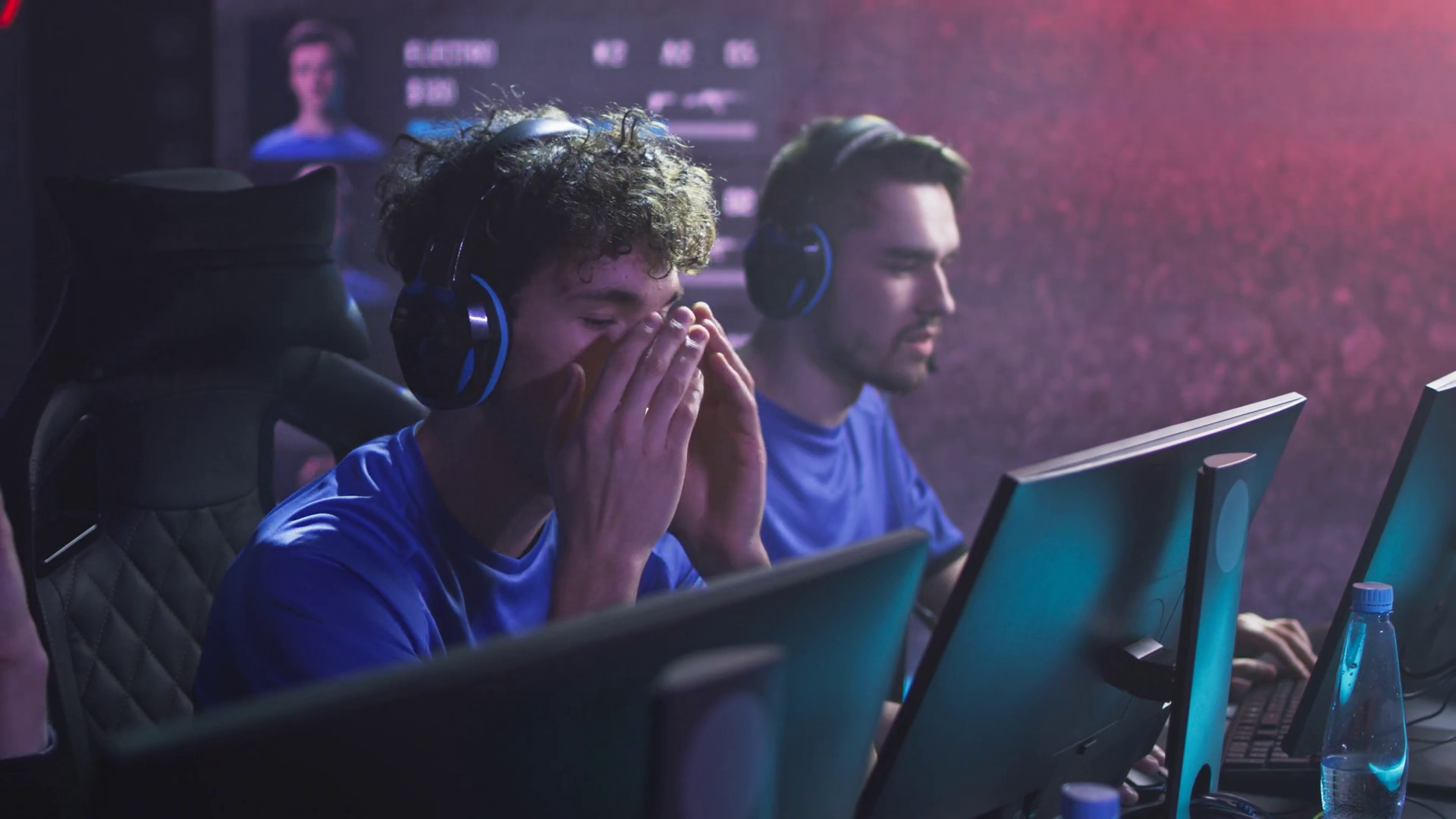 Exhausted gamer esportsman rubbing face and taking off headphones while ...