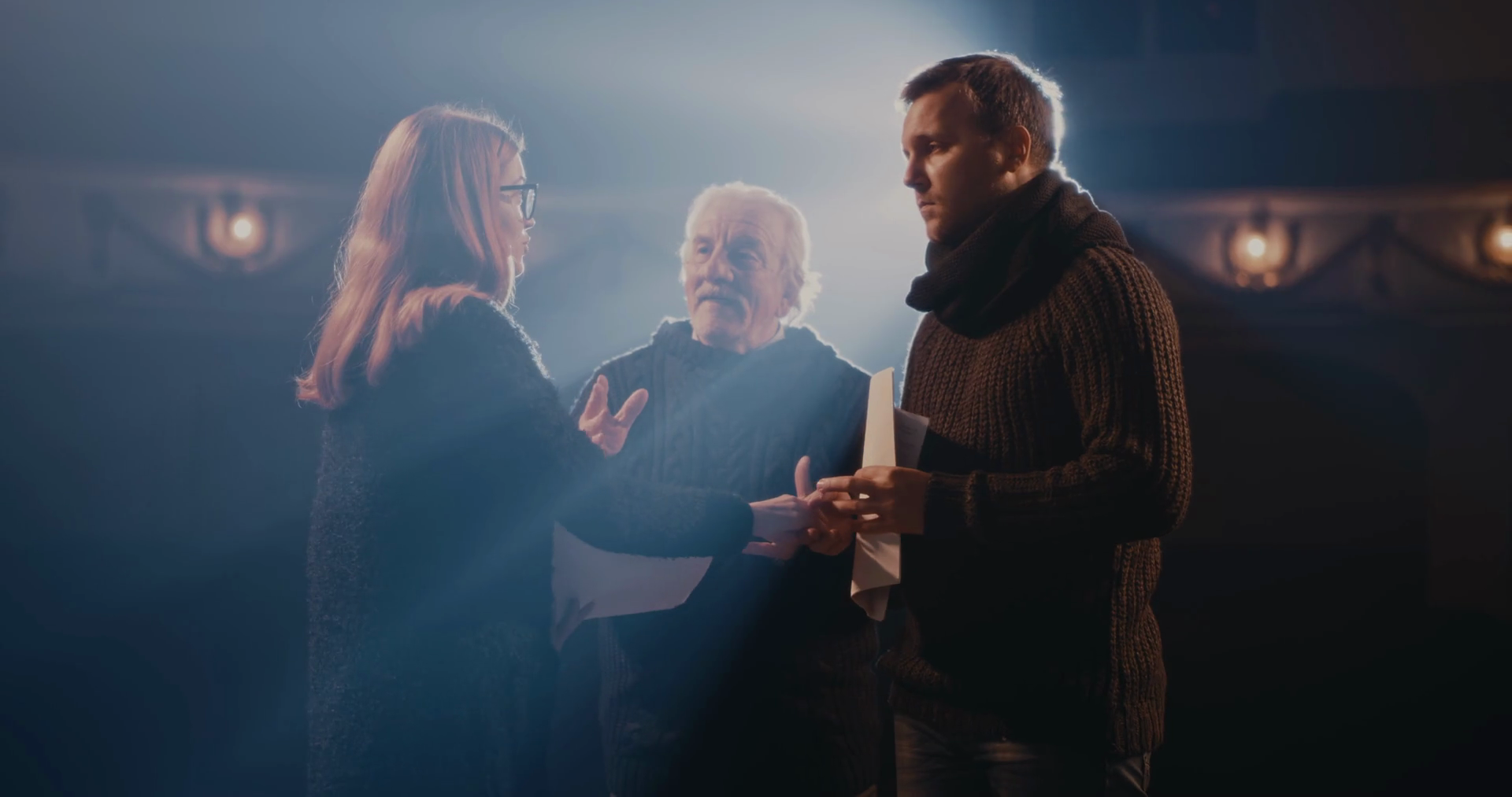 Actor and actress with scripts holding hands and speaking with each ...