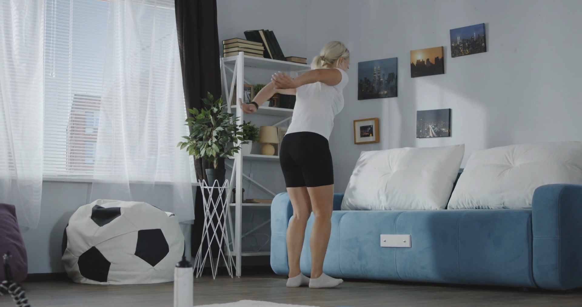 Full shot of a young woman jumping on a sofa during home workout Stock ...