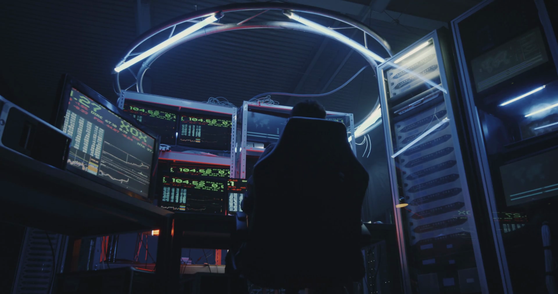 Medium close-up of a young hacker using a computer with multiple ...