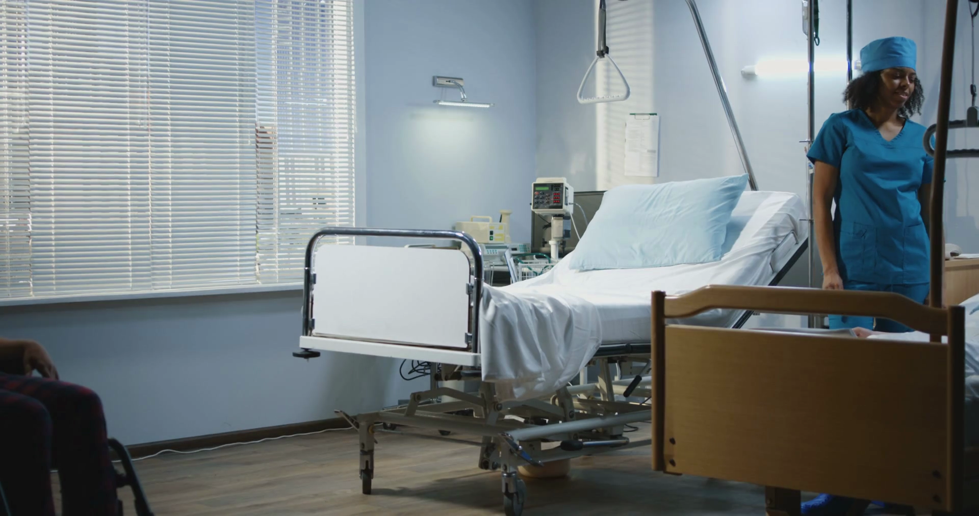 Medium shot of doctor and male nurse lifting patient to bed in hospital ...