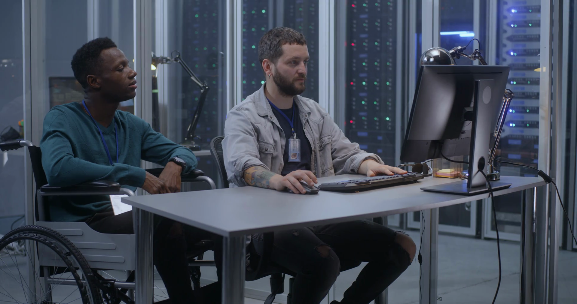 Medium shot of young programmers working in a data center together ...