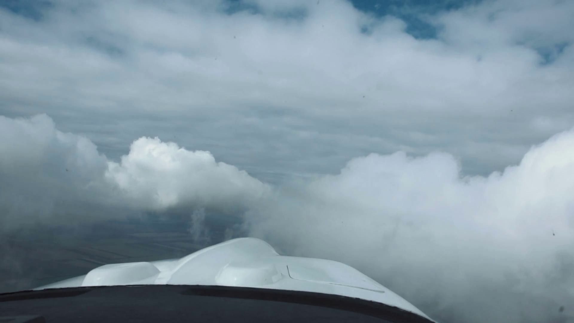 View from a small plane of grey storm clouds over an open landscape ...
