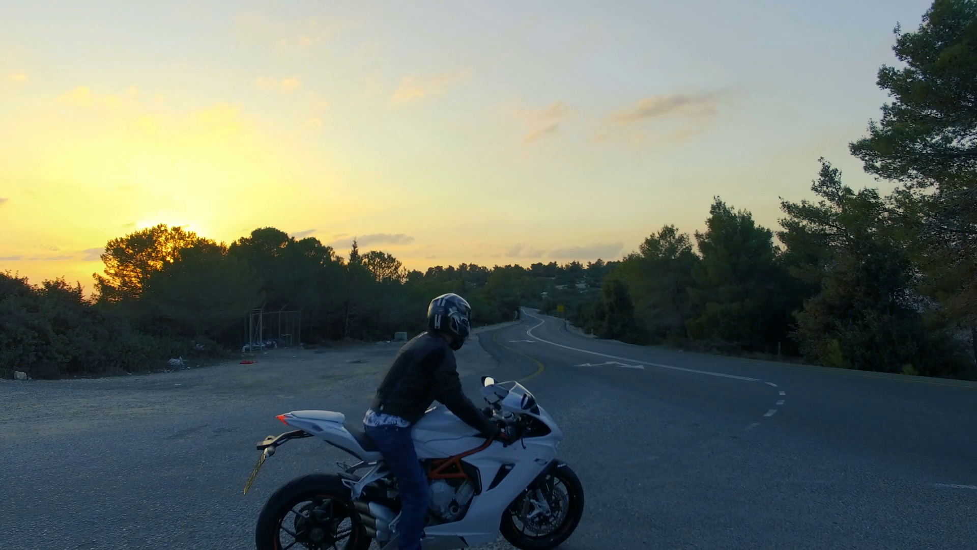 Aerial shot of a motorcycle driving away towards the sunset Stock Video ...