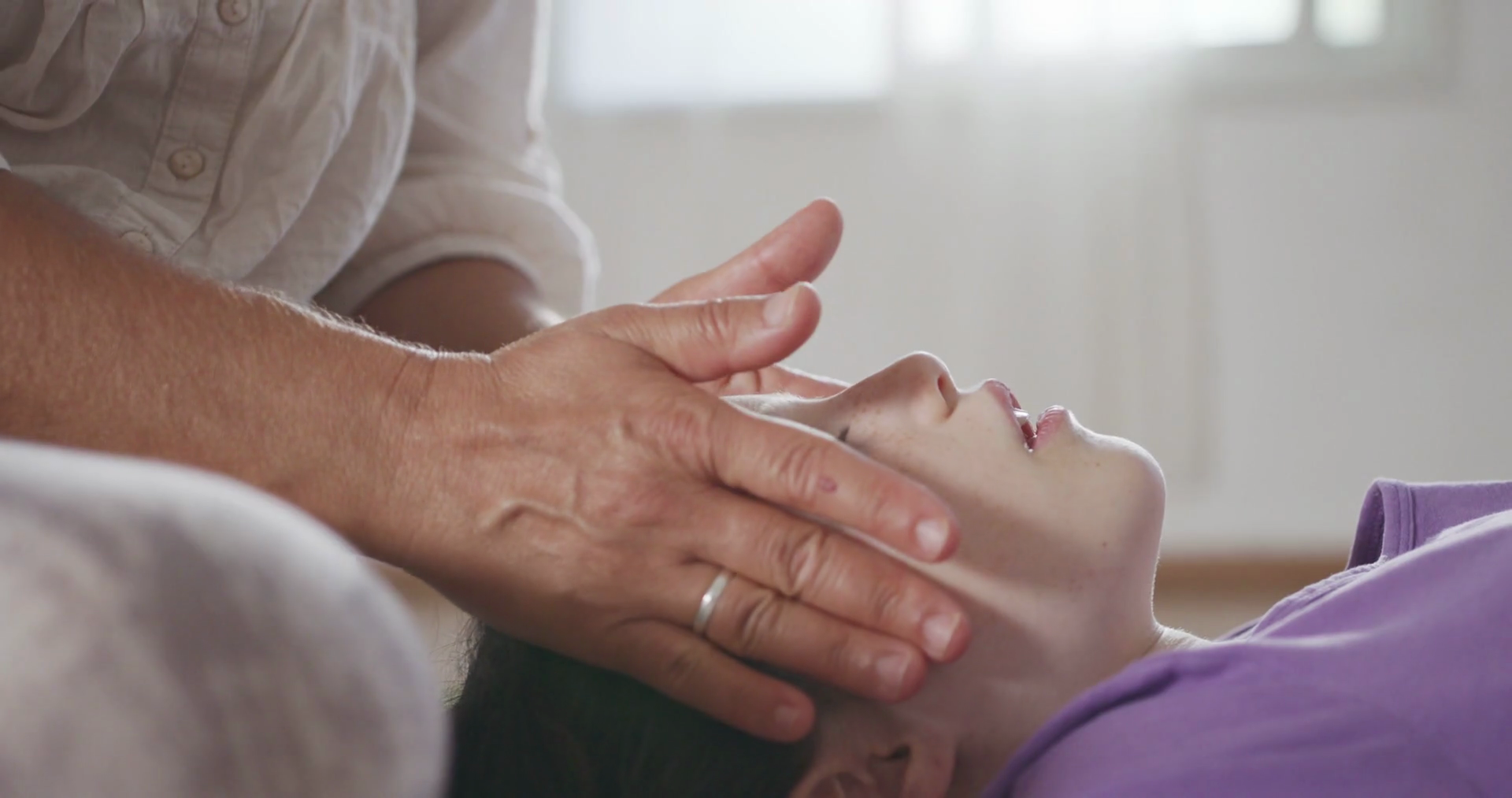 Shiatsu treatment. Masseuse giving gentle face treatment to a little ...