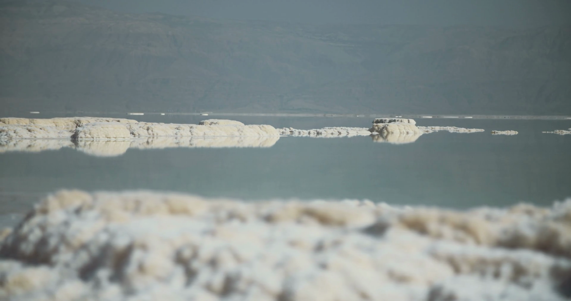 Tracking shot of salt deposits on the banks of the Dead Sea in israel ...
