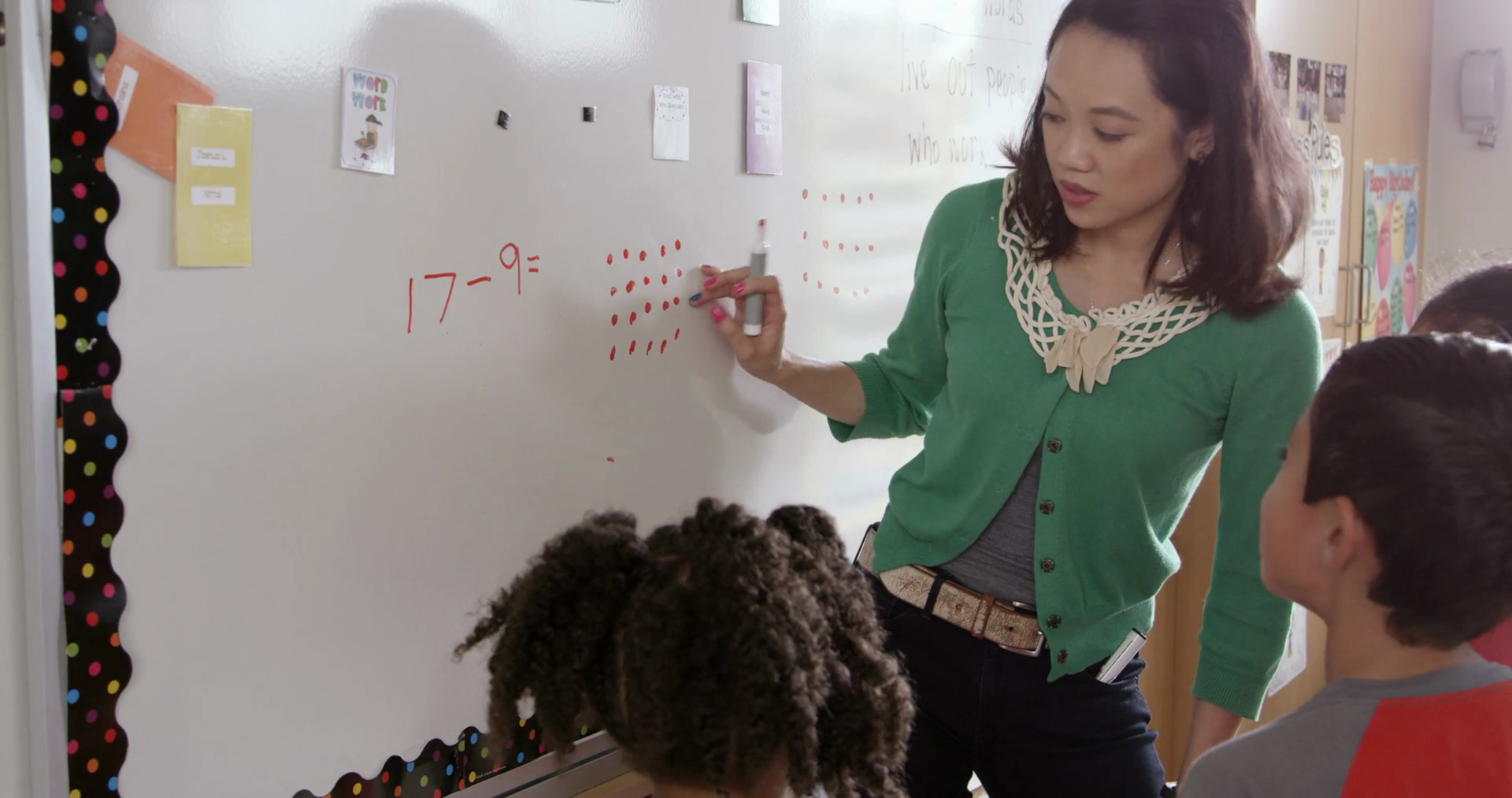 Elementary school math teacher works with kids at whiteboard Stock ...