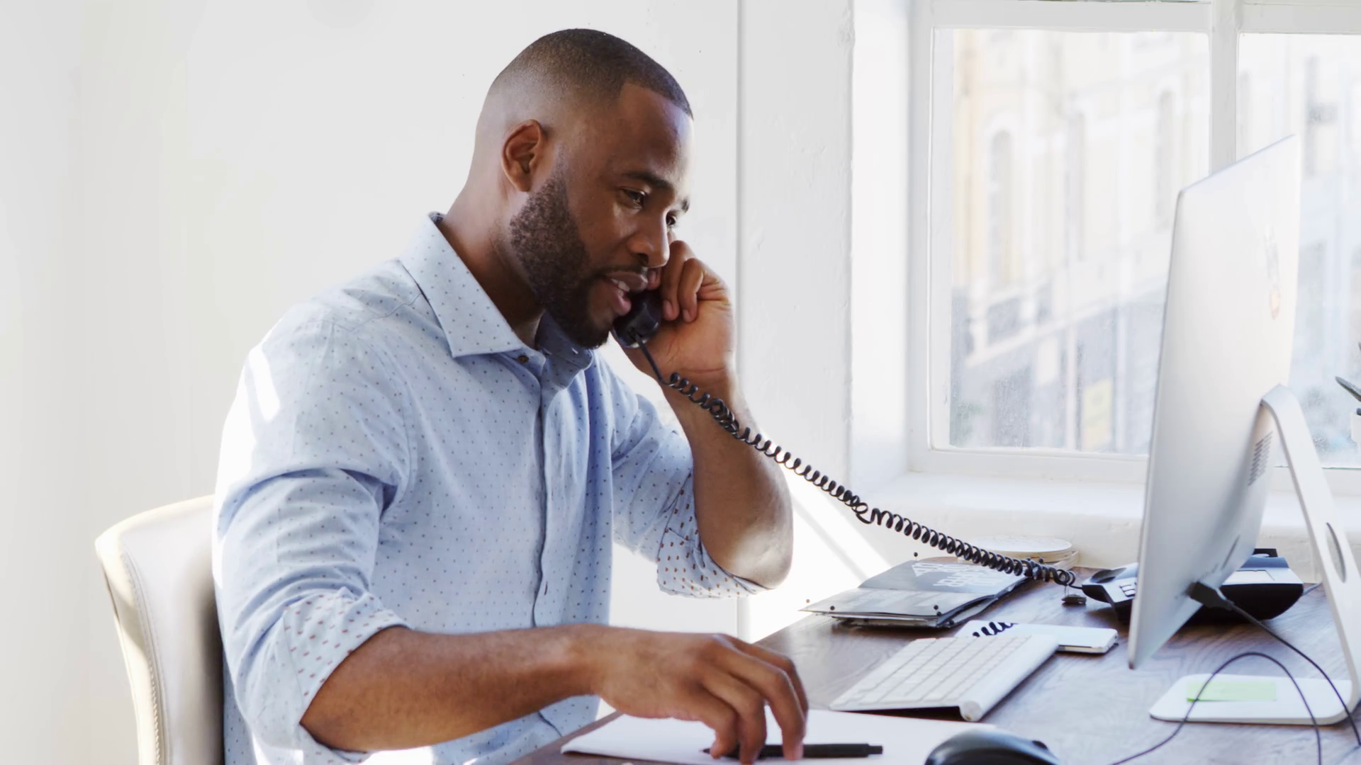 Young black man using phone and computer in office, close up Stock ...