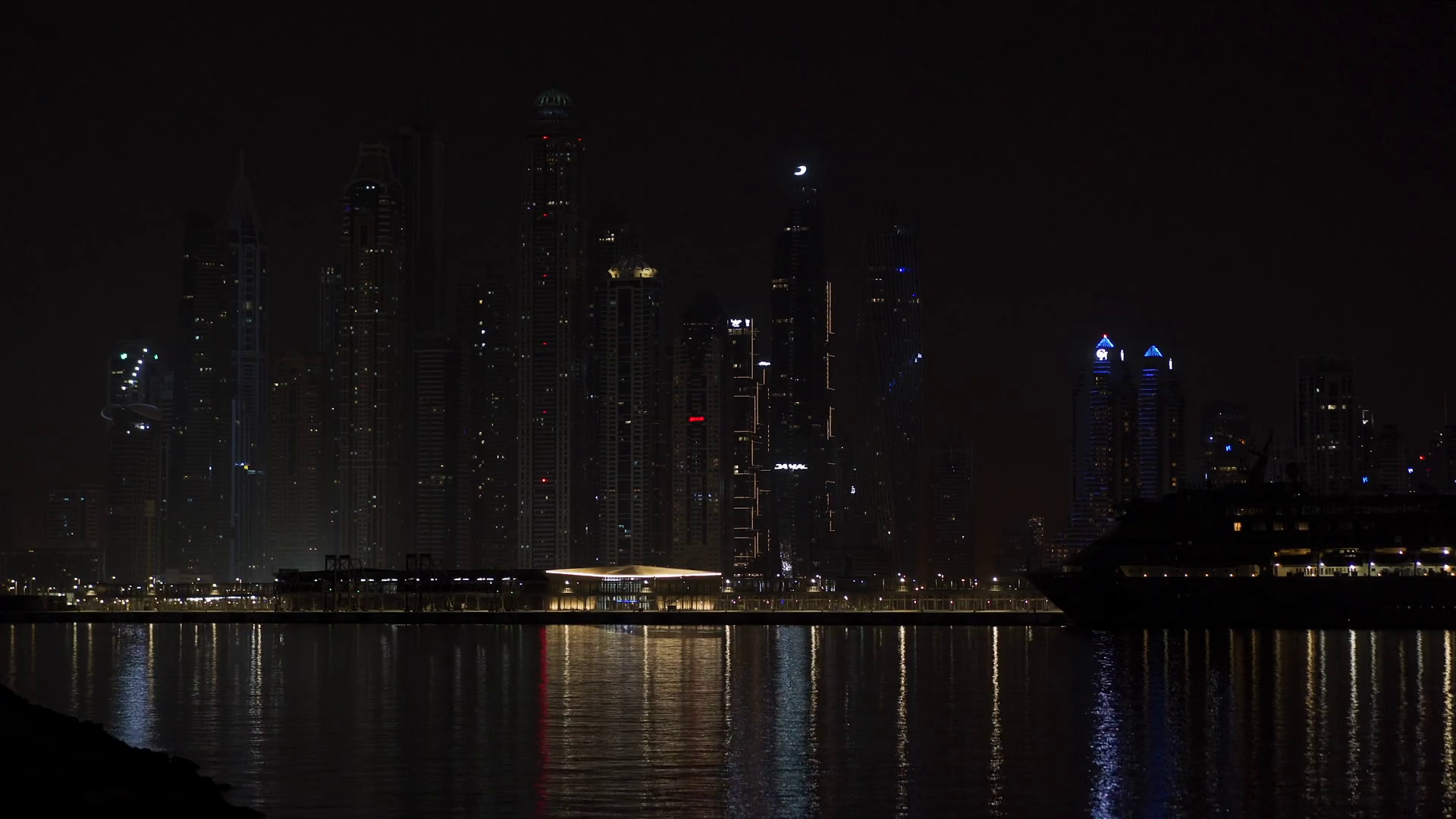 Night city. High-rise buildings glow at night by the sea. Stock Video ...