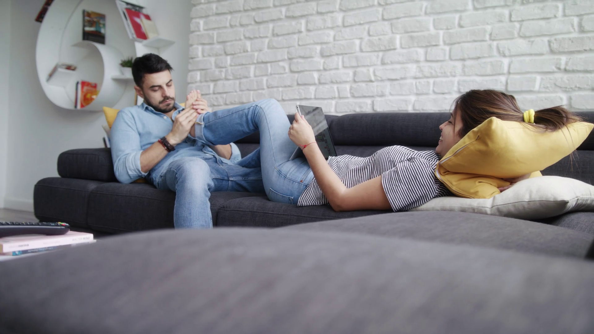 Man Massaging Girlfriend Feet On Sofa At Home Stock Footage SBV