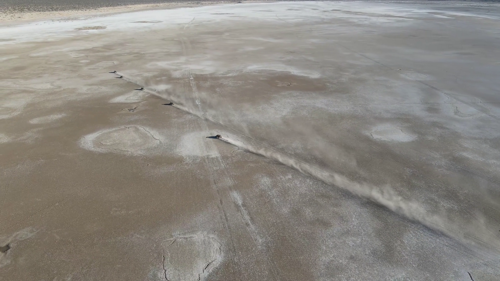 Aerial View Of Dune Buggies Racing Through The Desert Kicking Up Dust ...