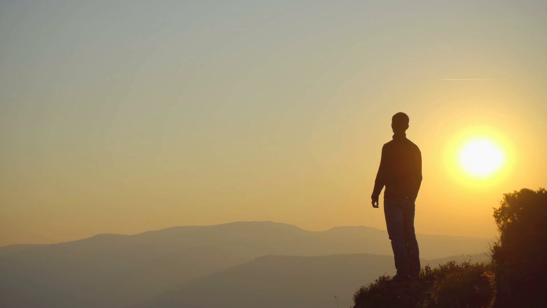 2 in 1 video! The man stand on the mountain on the background of sunset ...