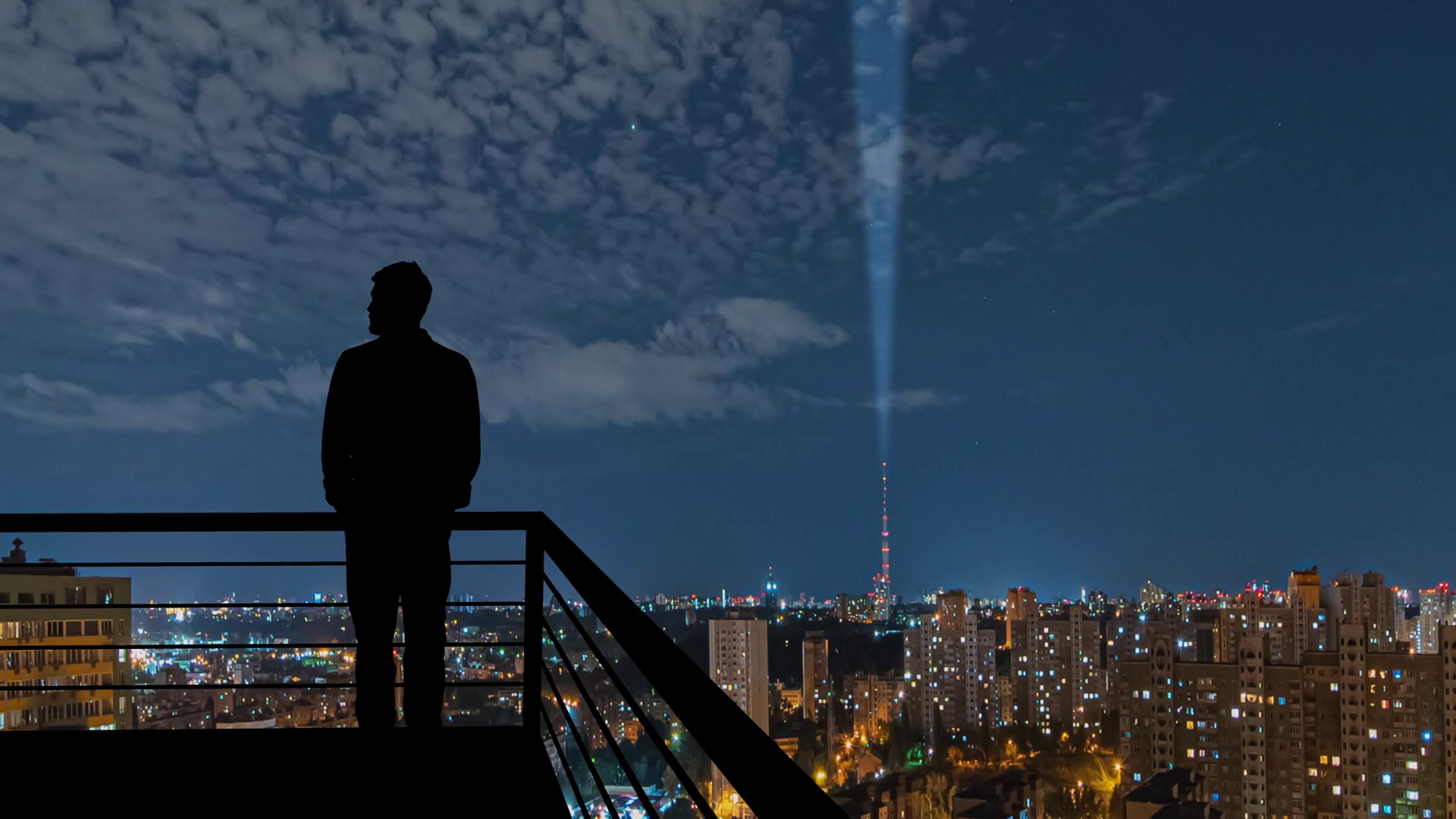 The man stands on the balcony on the night urban background. hyperlapse ...