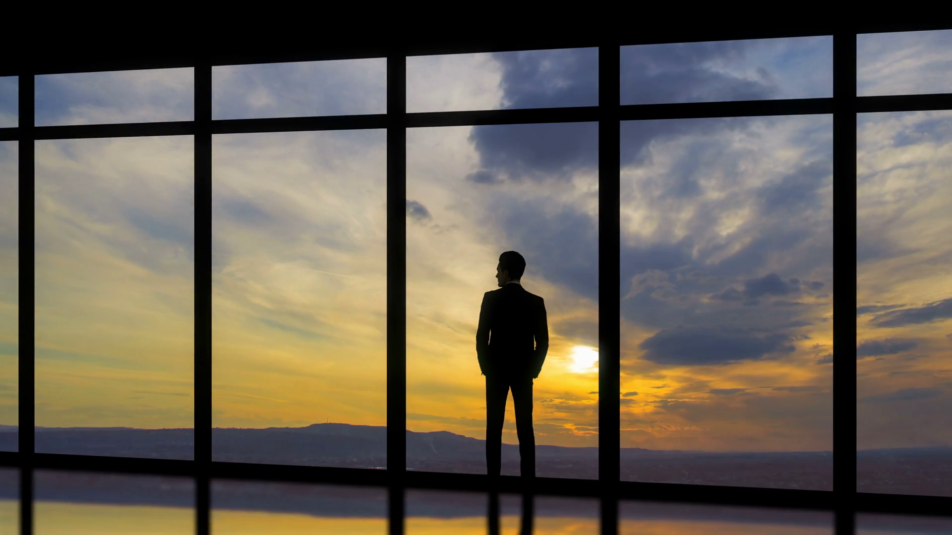 The man standing near windows on the sunset background. time lapse ...