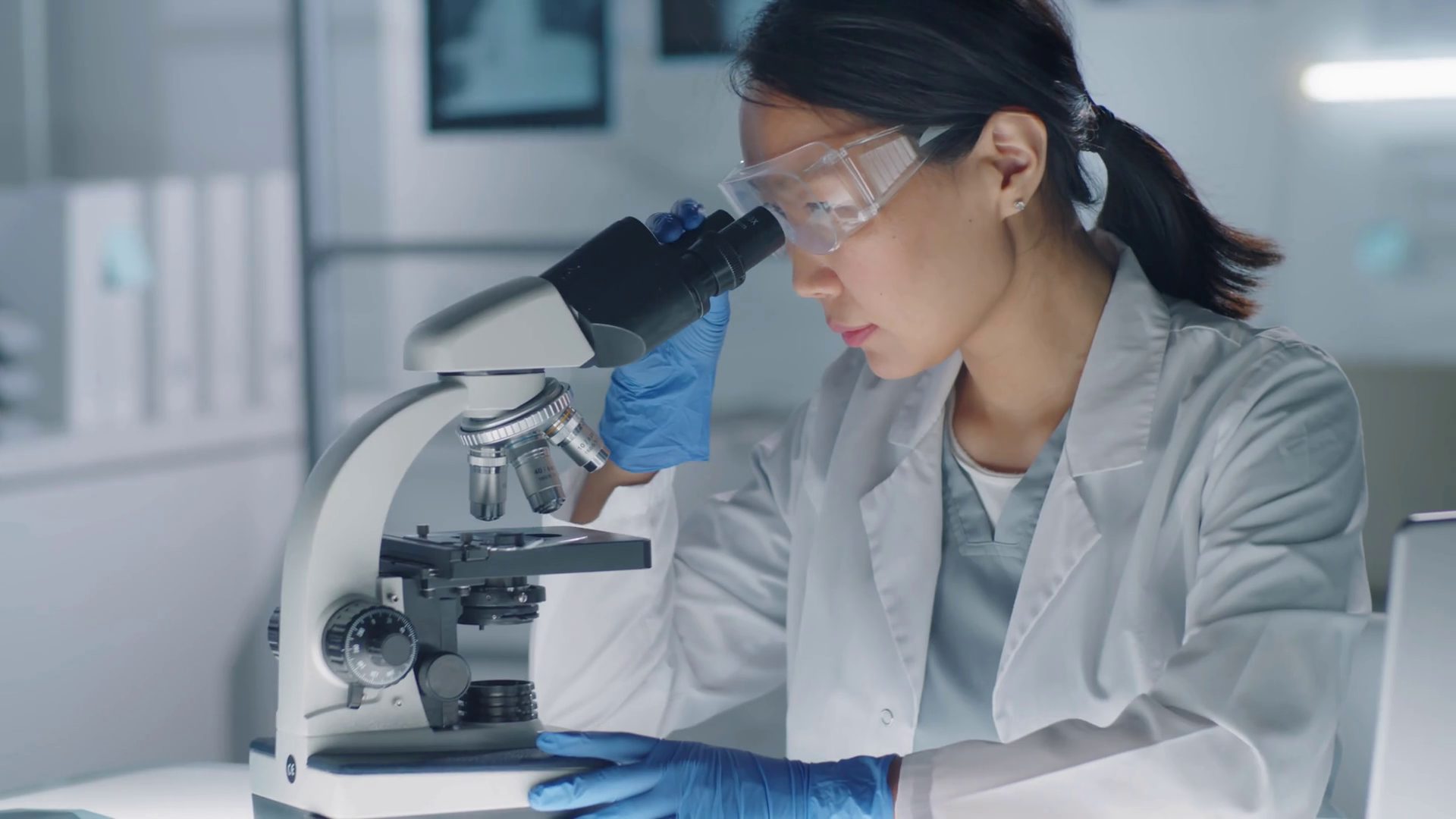 Modern Asian laboratory worker wearing white coat, protective gloves ...
