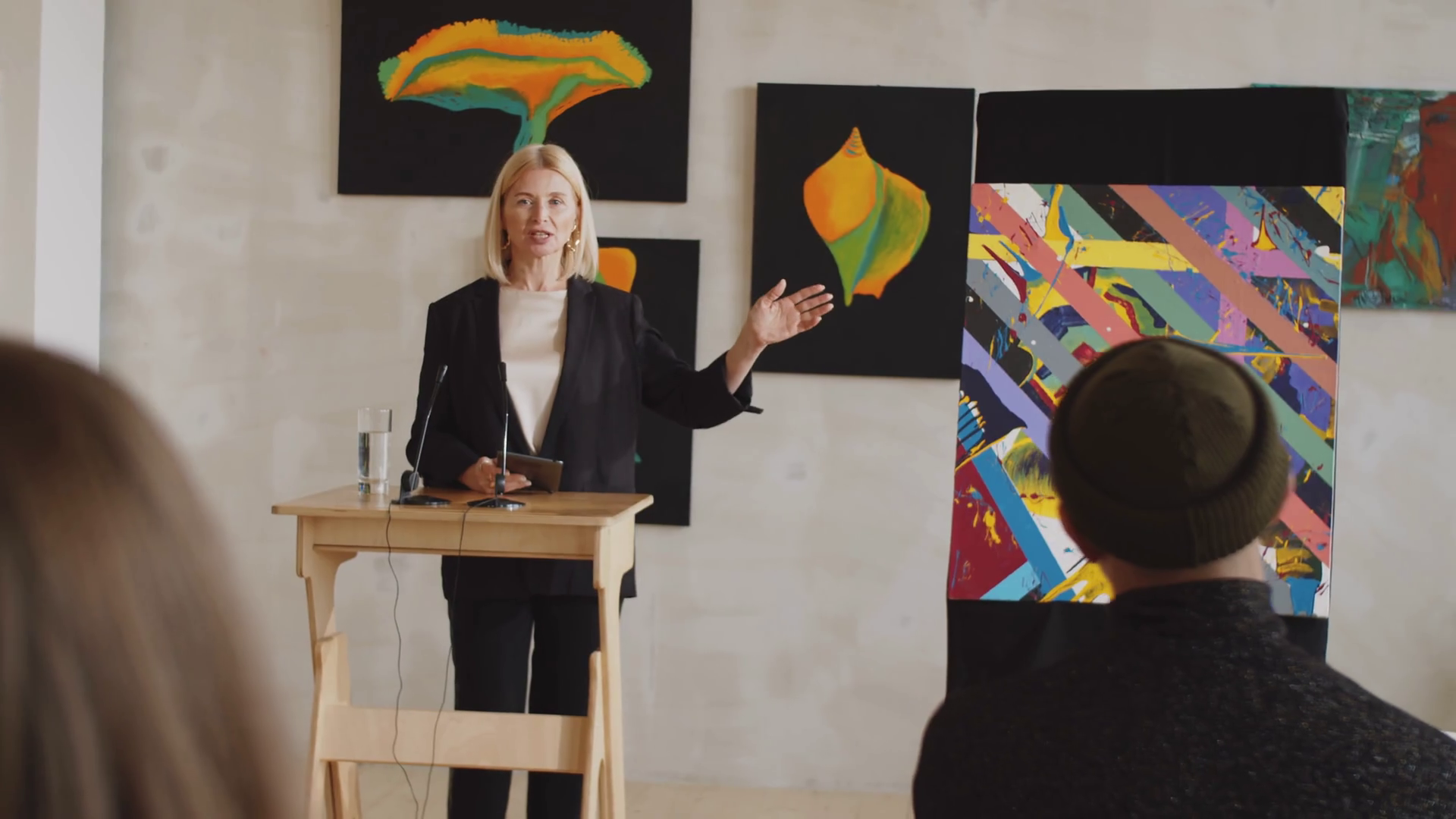 Beautiful mid-aged female auctioneer standing at rostrum, holding ...