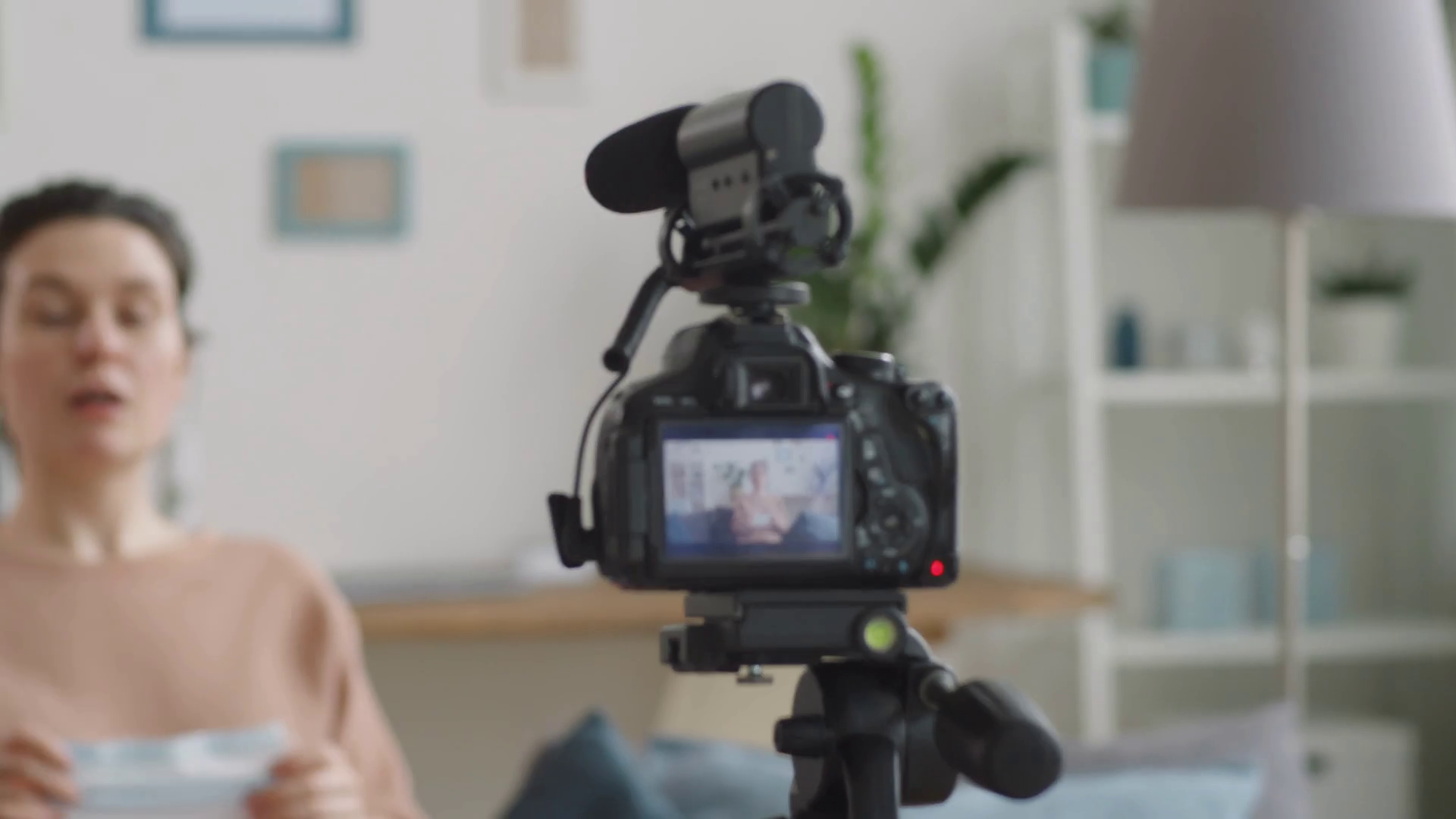 Young female vlogger demonstrating how to wear medical face mask and ...