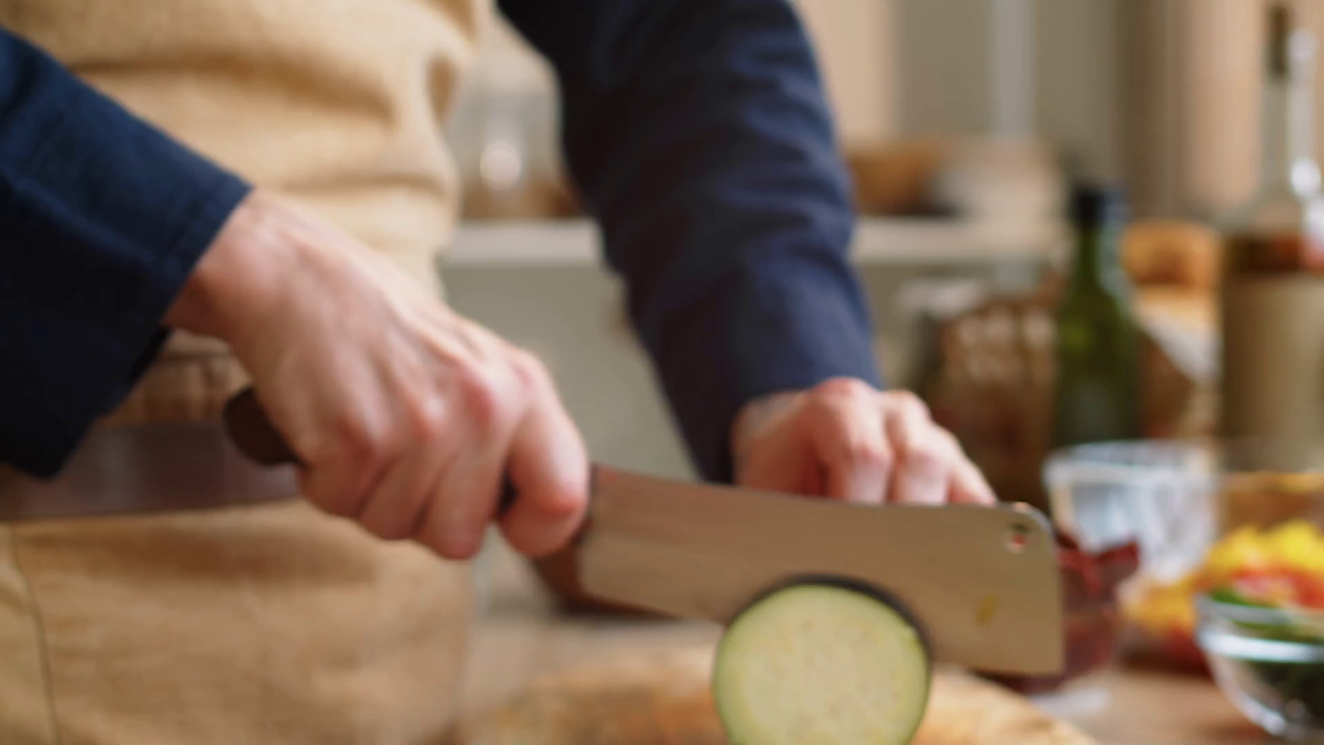 Close up shot of hands of male cook in apron using butcher knife while ...