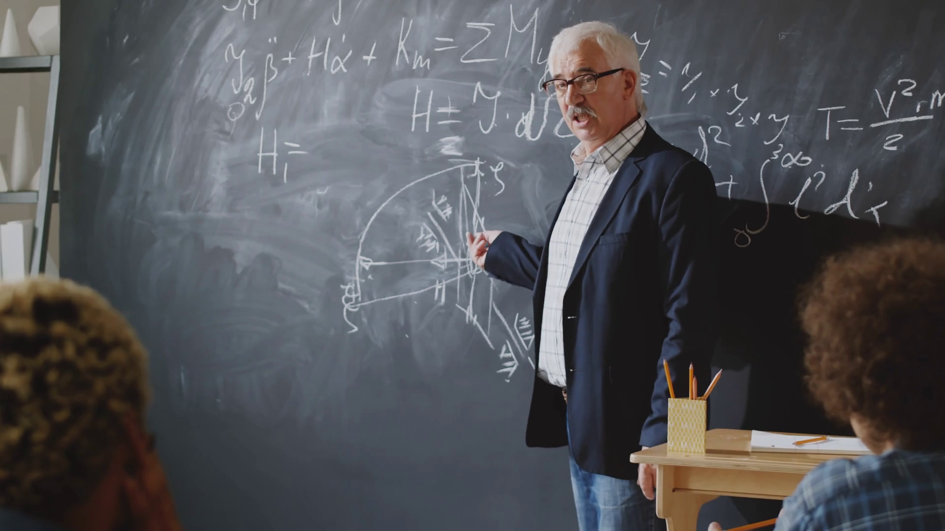 Senior professor explaining graph on chalkboard during math lesson ...