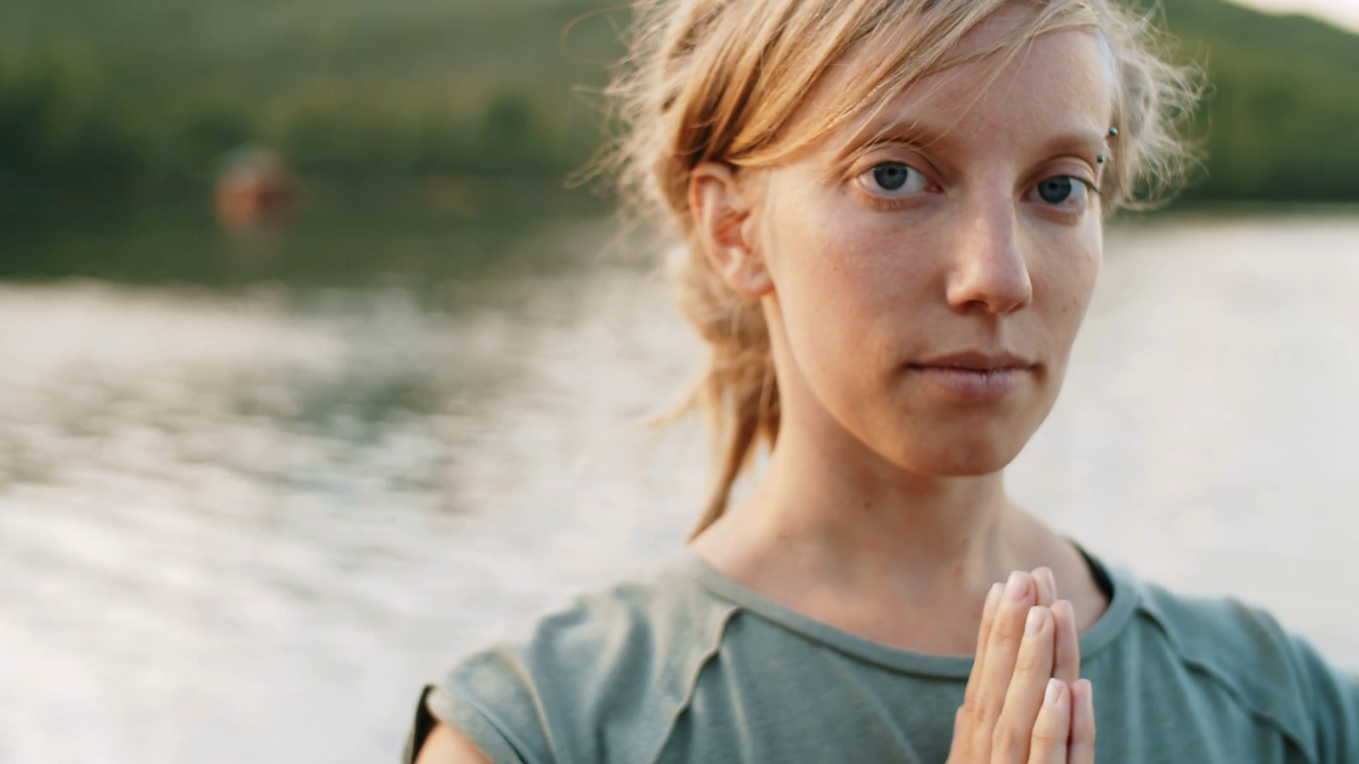 Chest up portrait shot of young Caucasian woman with hands clasped in ...