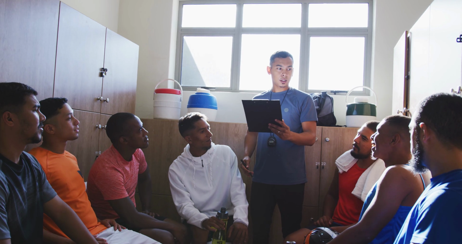 Coach talking to soccer players in the locker room Stock Video Footage ...