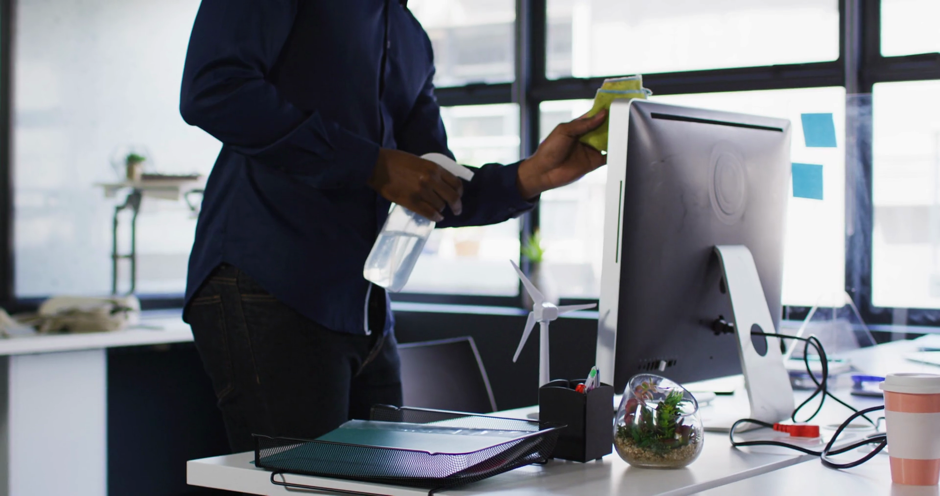 African american man wearing face mask cleaning his computer with ...