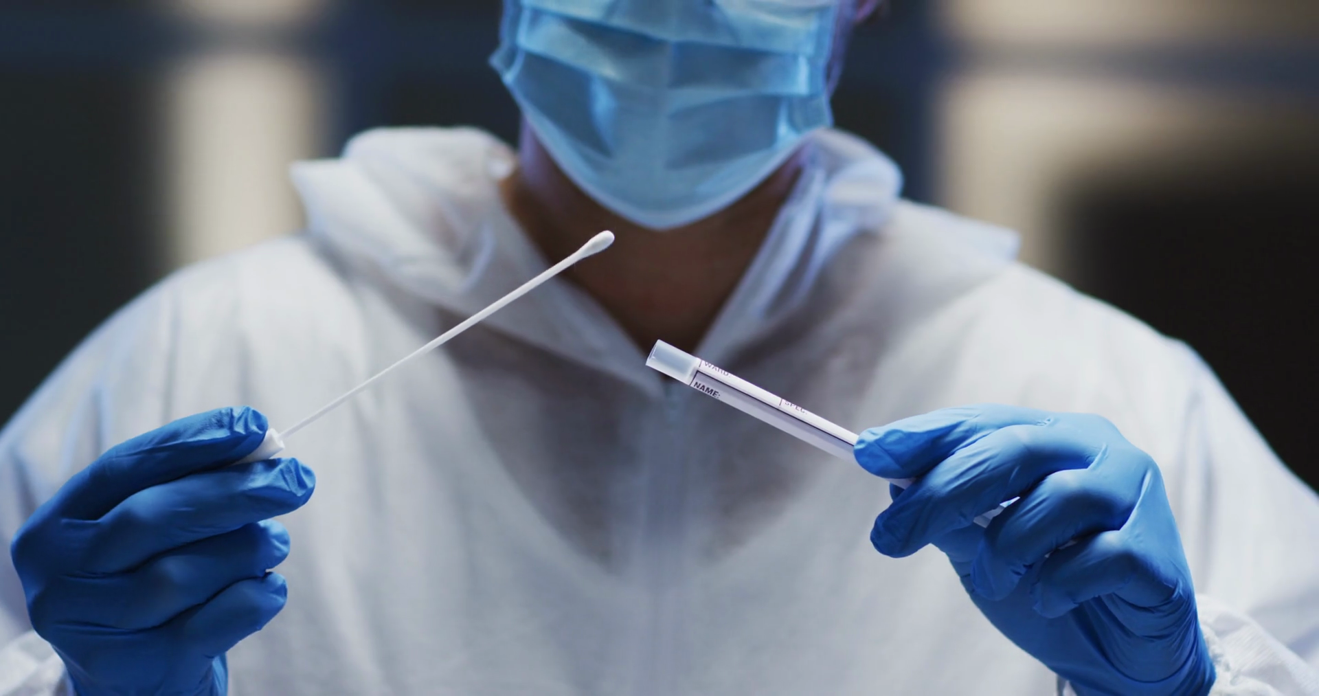 Medical worker in protective clothing and face mask examining patient ...