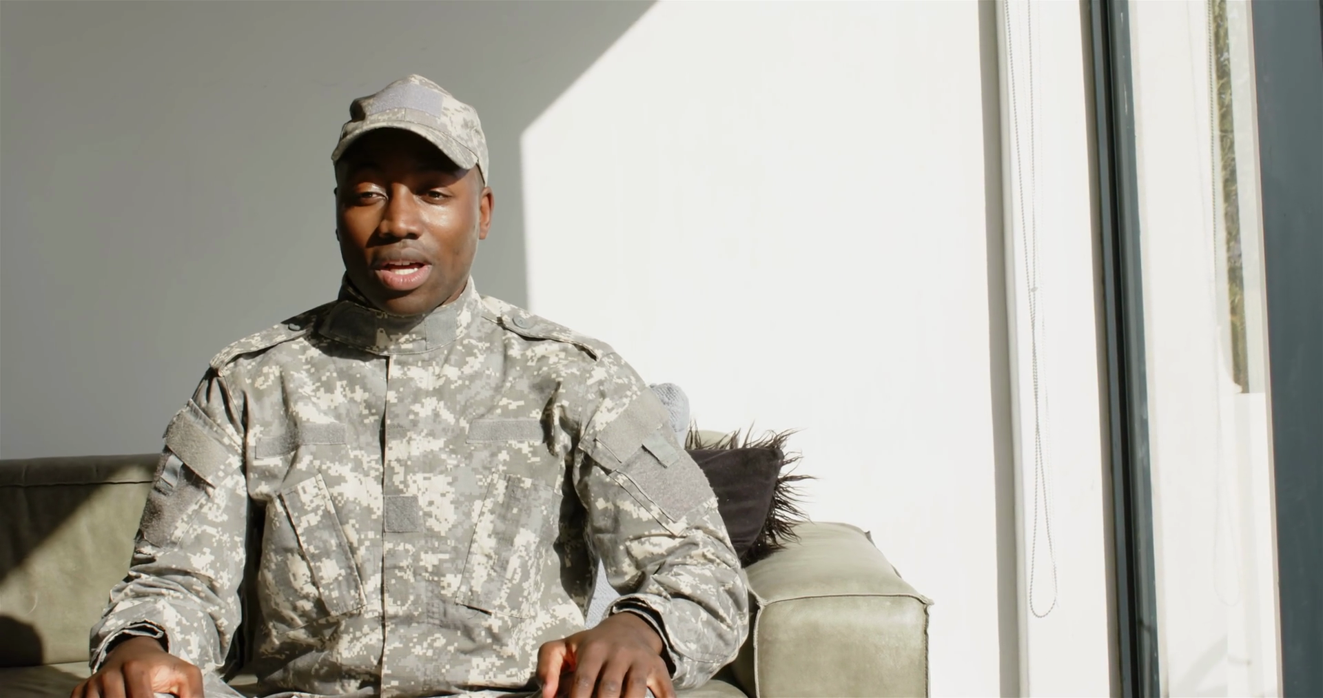 Military Man Sitting On Couch Adjusting Cap Stock Footage SBV-352121869 ...