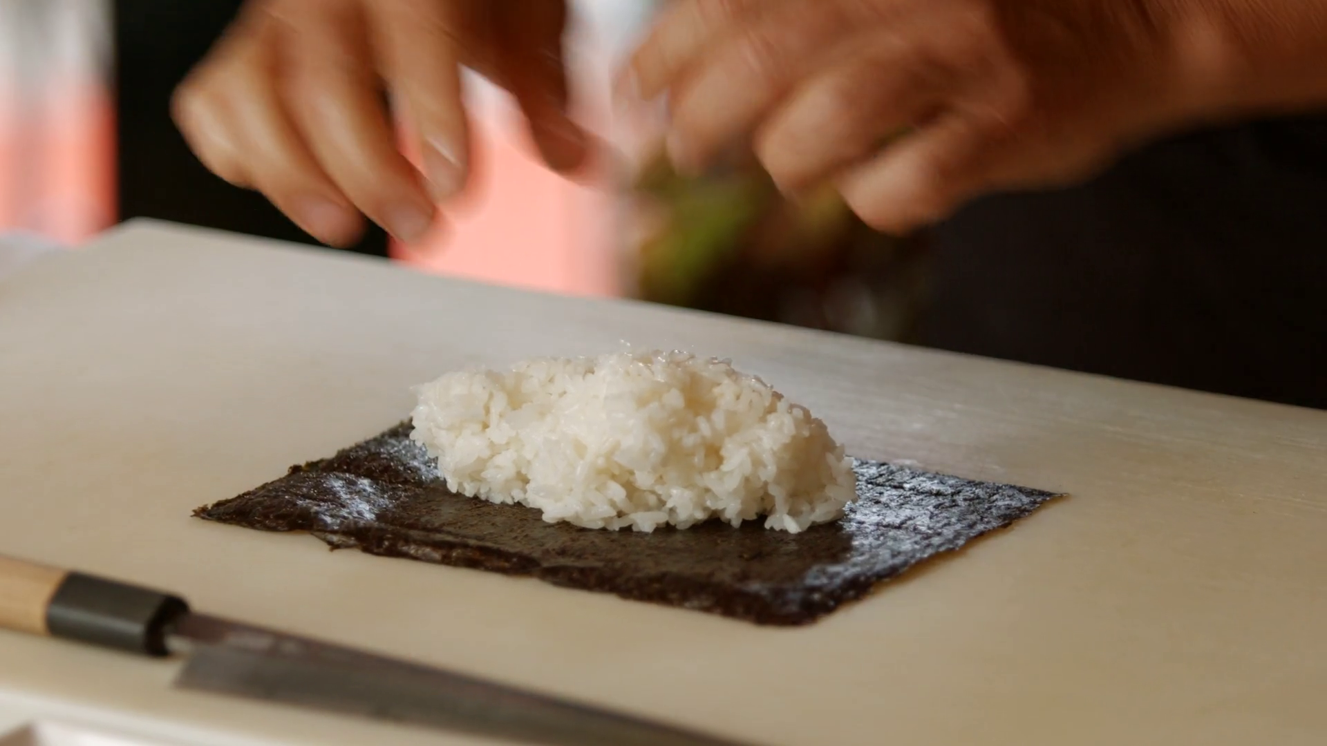 Male hands making sushi. Fingers working with white rice. Master's work ...
